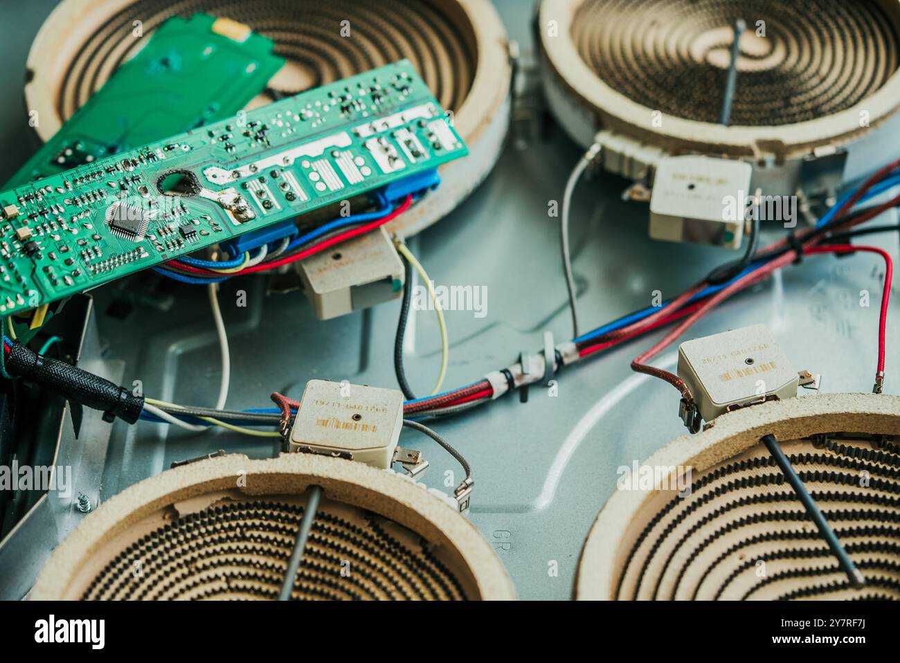 Close-up of electronic circuit board with wiring and heating coils in a ...