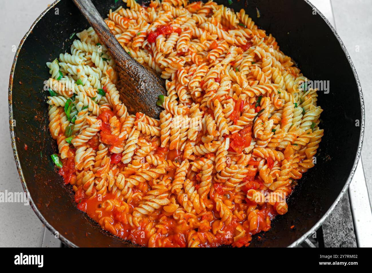 Cooking pasta with tomato sauce in a wok Stock Photo - Alamy