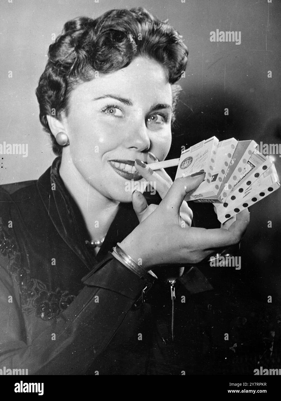 I.N.P. PHOTO SHOWS. A young lady about to light 8 cigarette - by ...