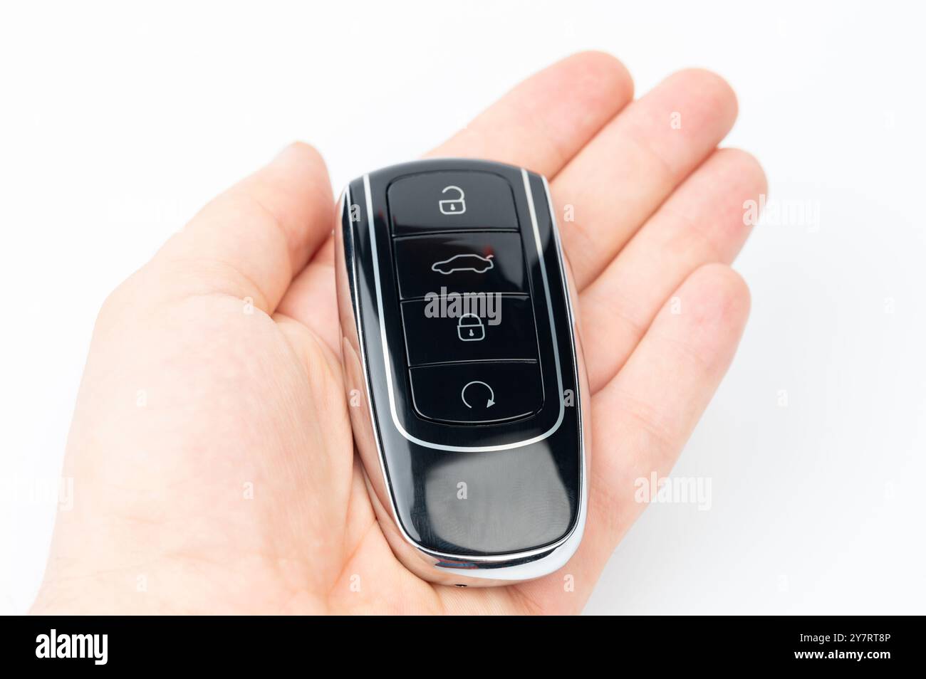 Black metal wireless car key in hand isolated on white studio ...