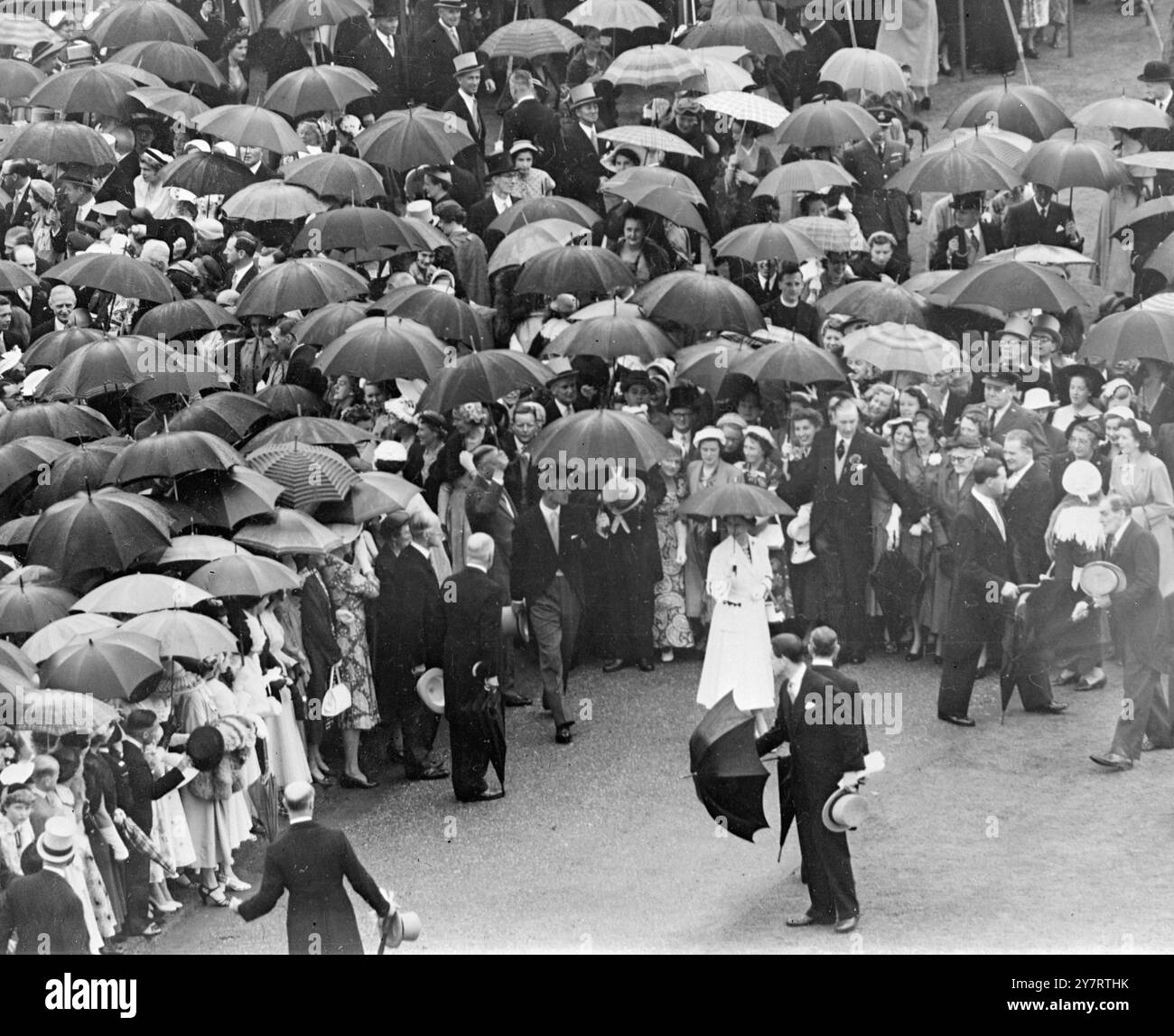 SEA OF UMBRELLAS WHEN THE QUEEN GOES AMONG HER GUESTSPhoto shows The ...
