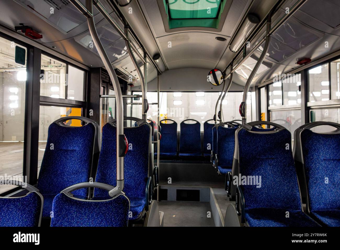 Interior of a modern city bus with blue comfortable seats and windows ...
