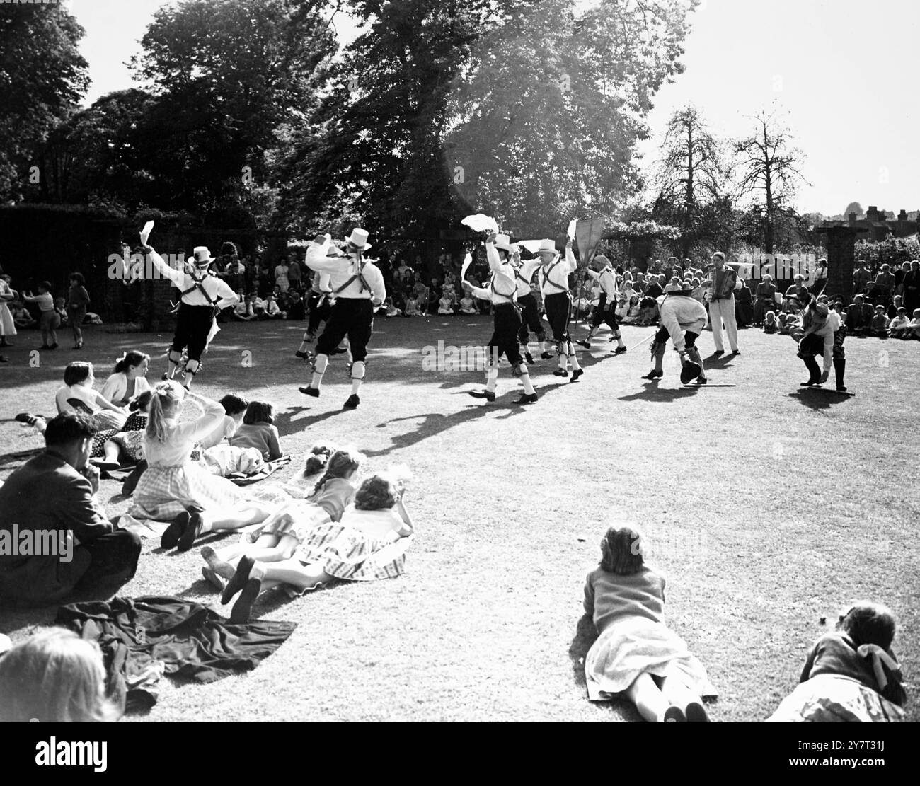 Morris Dancers performing in a field, watched by schoolchildren, Kent ...