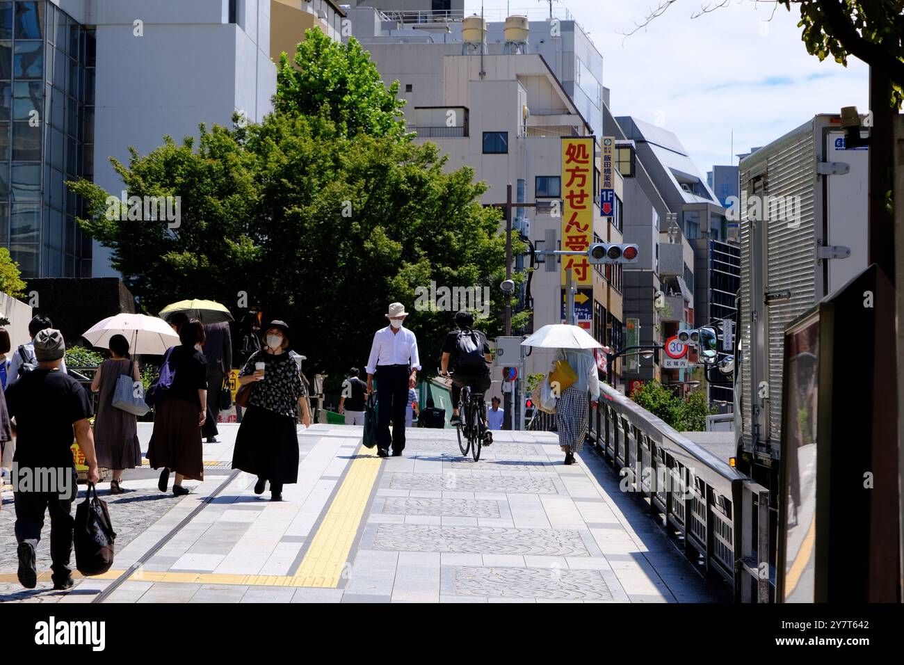 Pedestrians and cyclist on Usshigome Bridge in Kagurazaka neighborhood ...