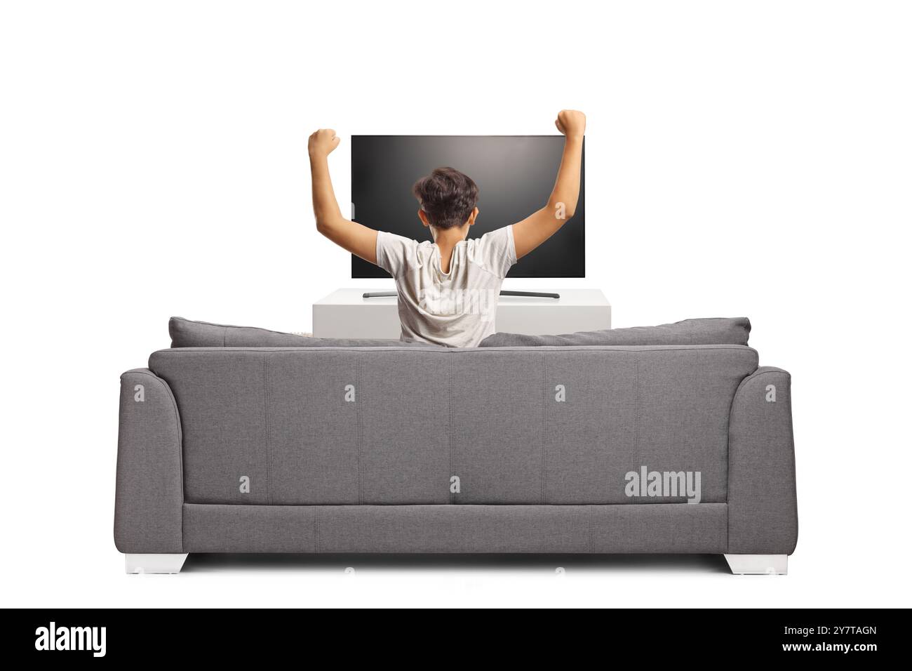 Rear view shot of a teenage boy cheering in front of tv screen isolated ...