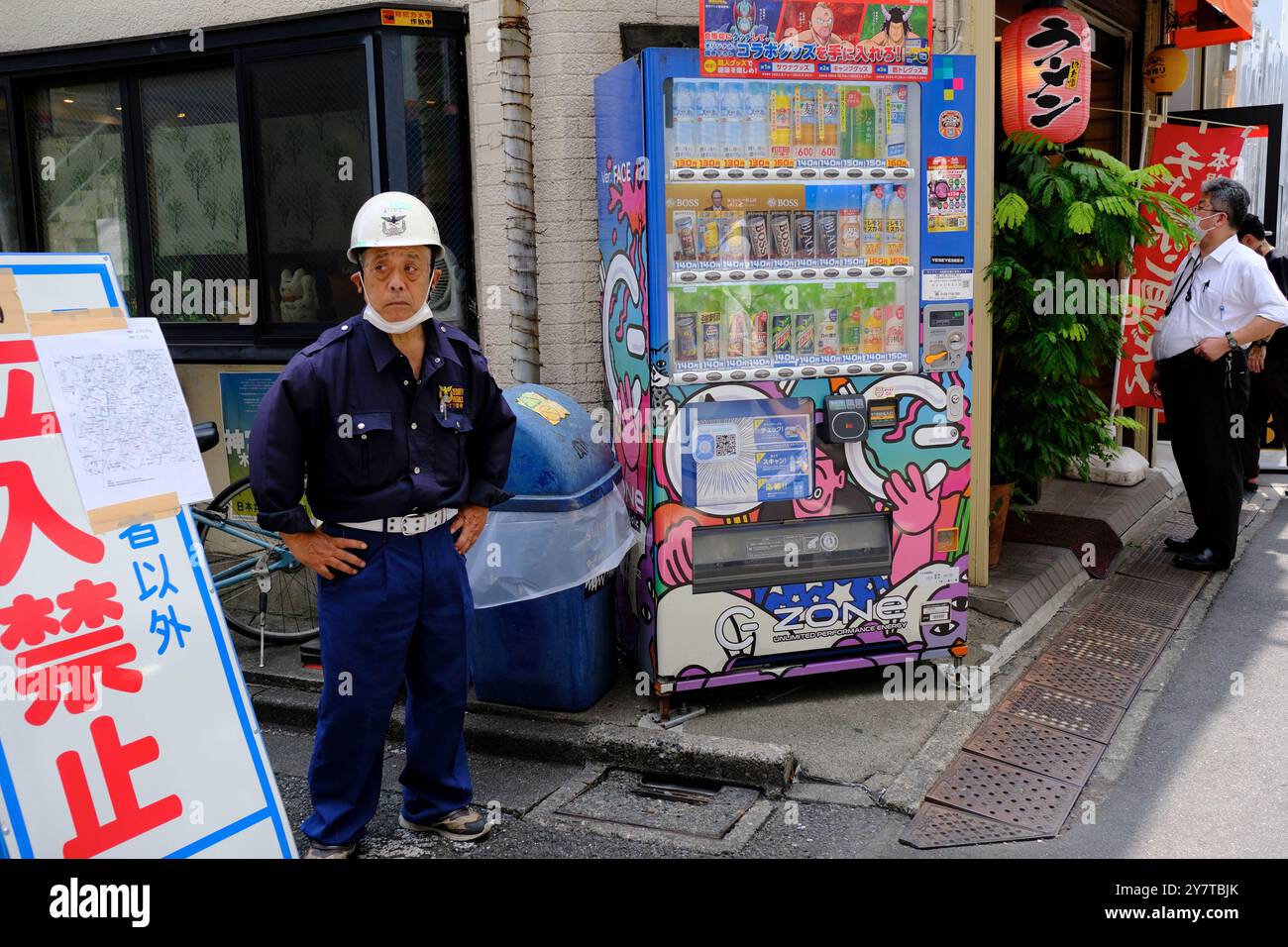 A uniformed worker guarding the entrance of a construction site by the ...