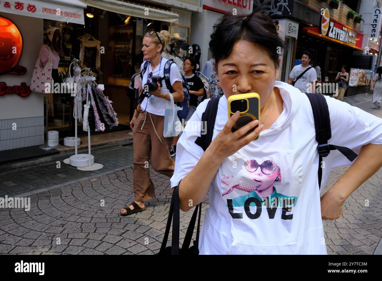 An Asian woman talking on her phone loudly in Takeshita dori street ...