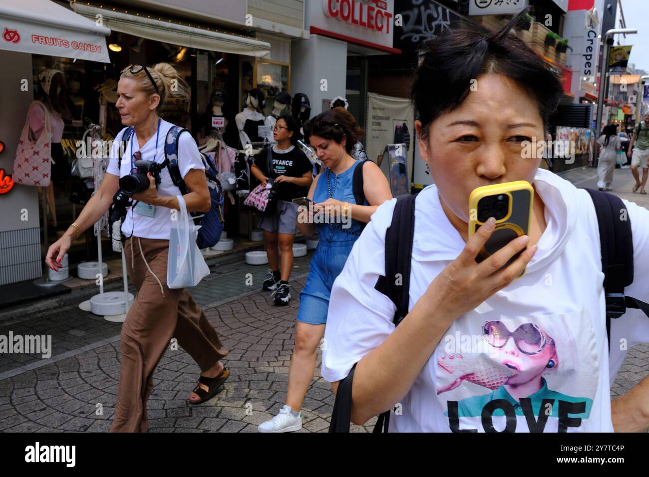 An Asian woman talking on her phone loudly in Takeshita dori street ...