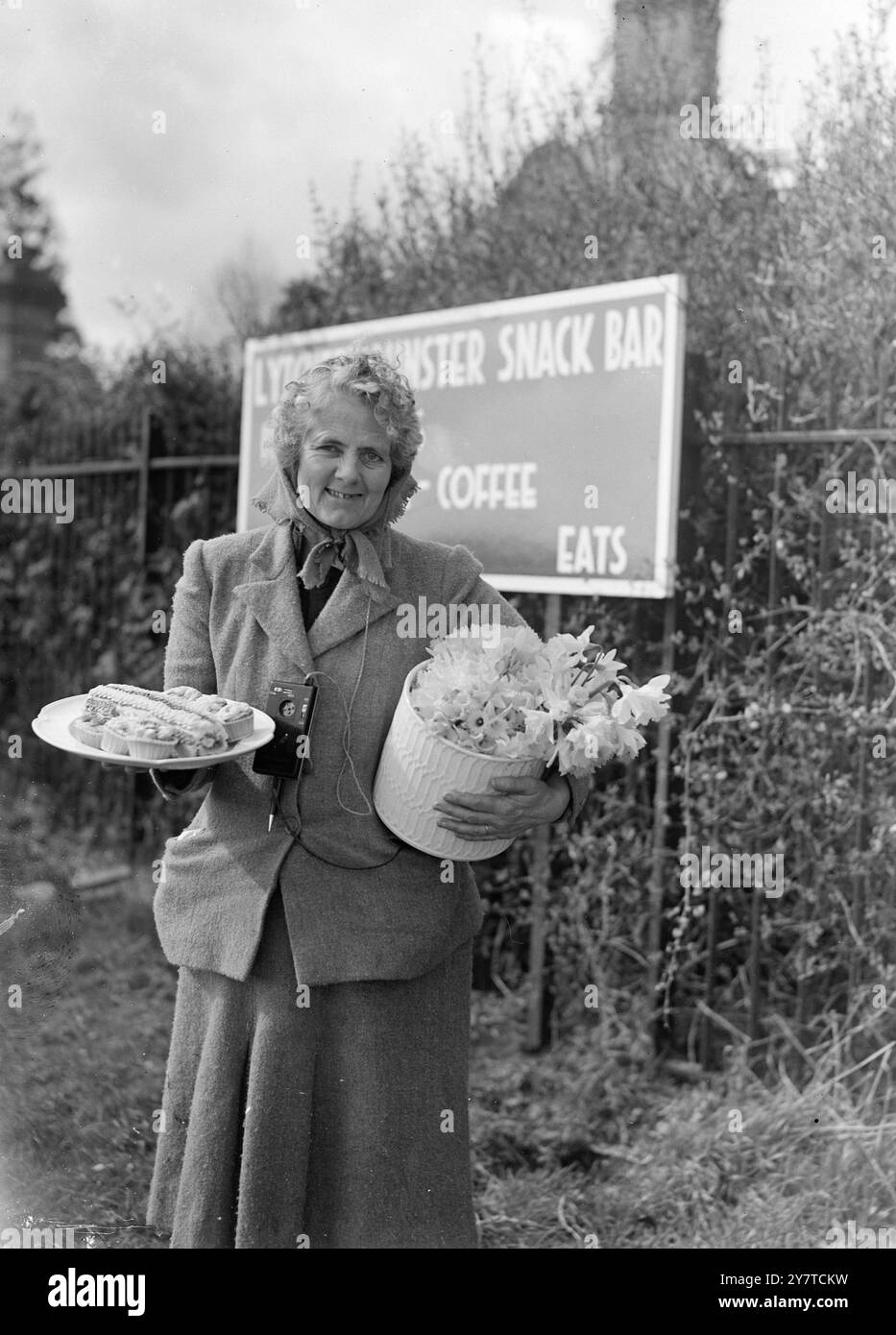 ENTERPRISING LADY OF THE MANOR OPENS A SNACK BAR Holding a plate of ...
