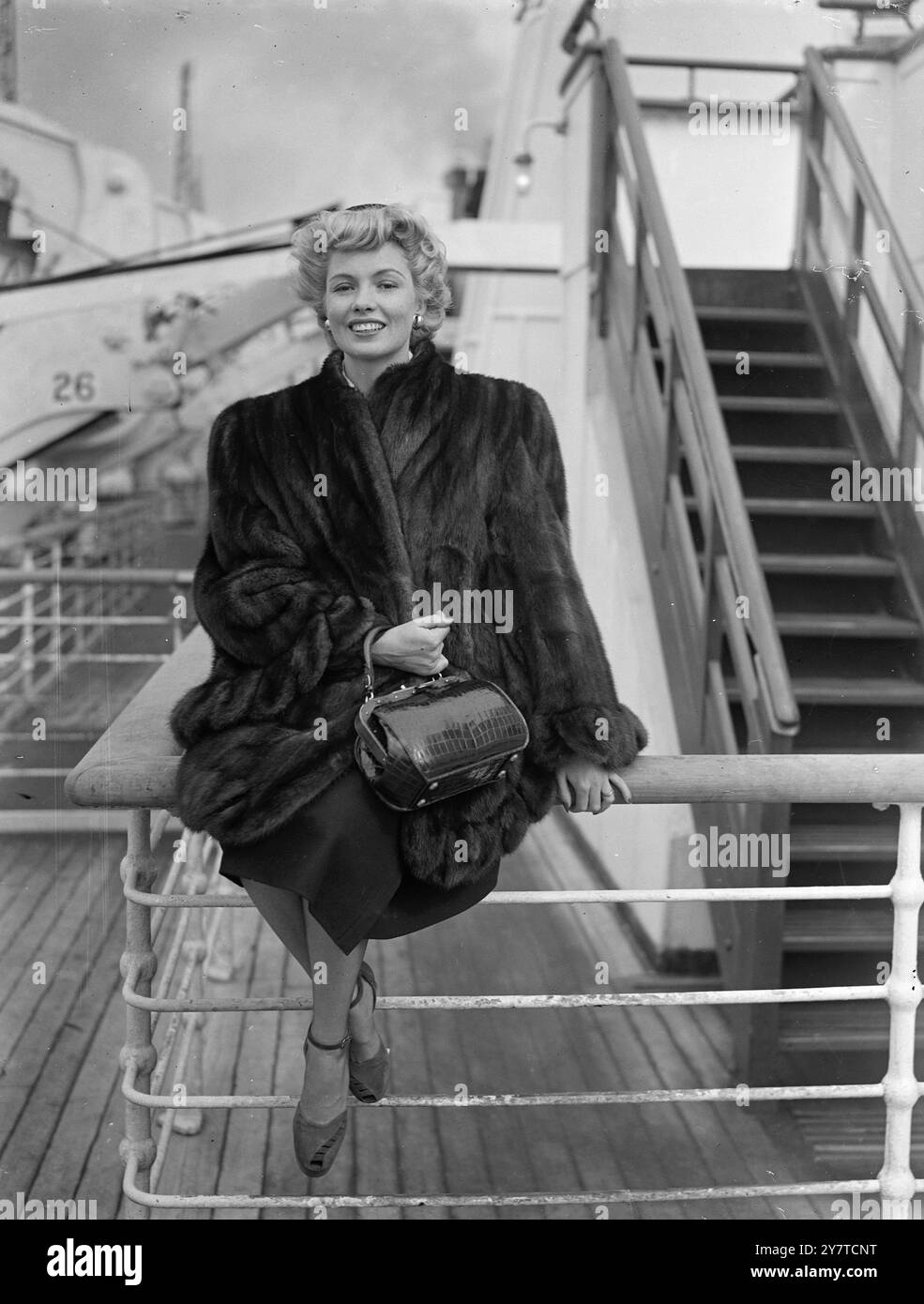 HOLIDAY BOUND Perched on the rail of the liner ' Queen Elizabeth' is ...