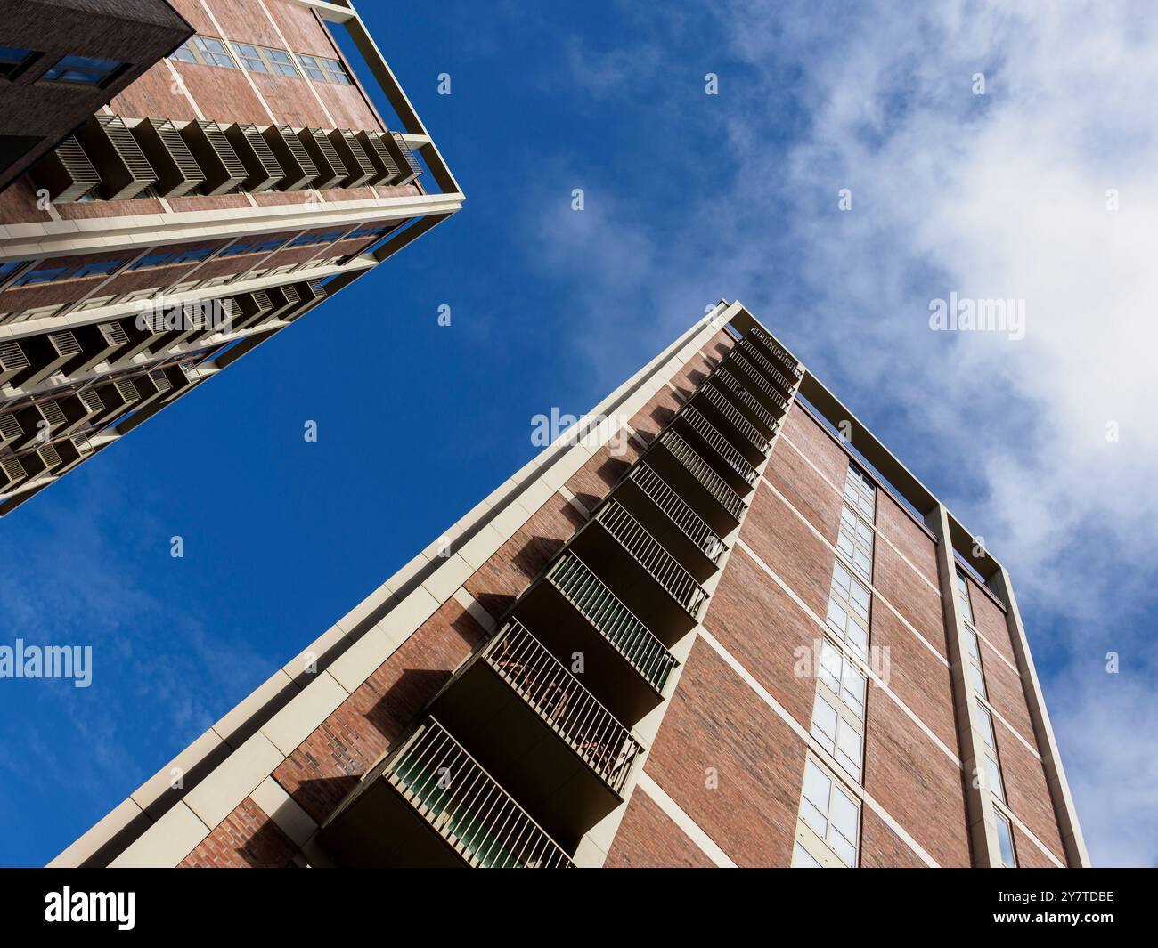 Two tall residential buildings with multiple balconies reaching up ...