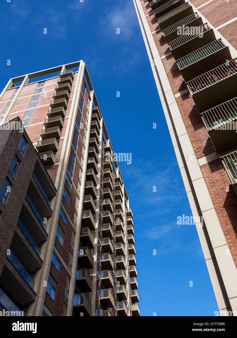 Two tall residential buildings with multiple balconies reaching up ...