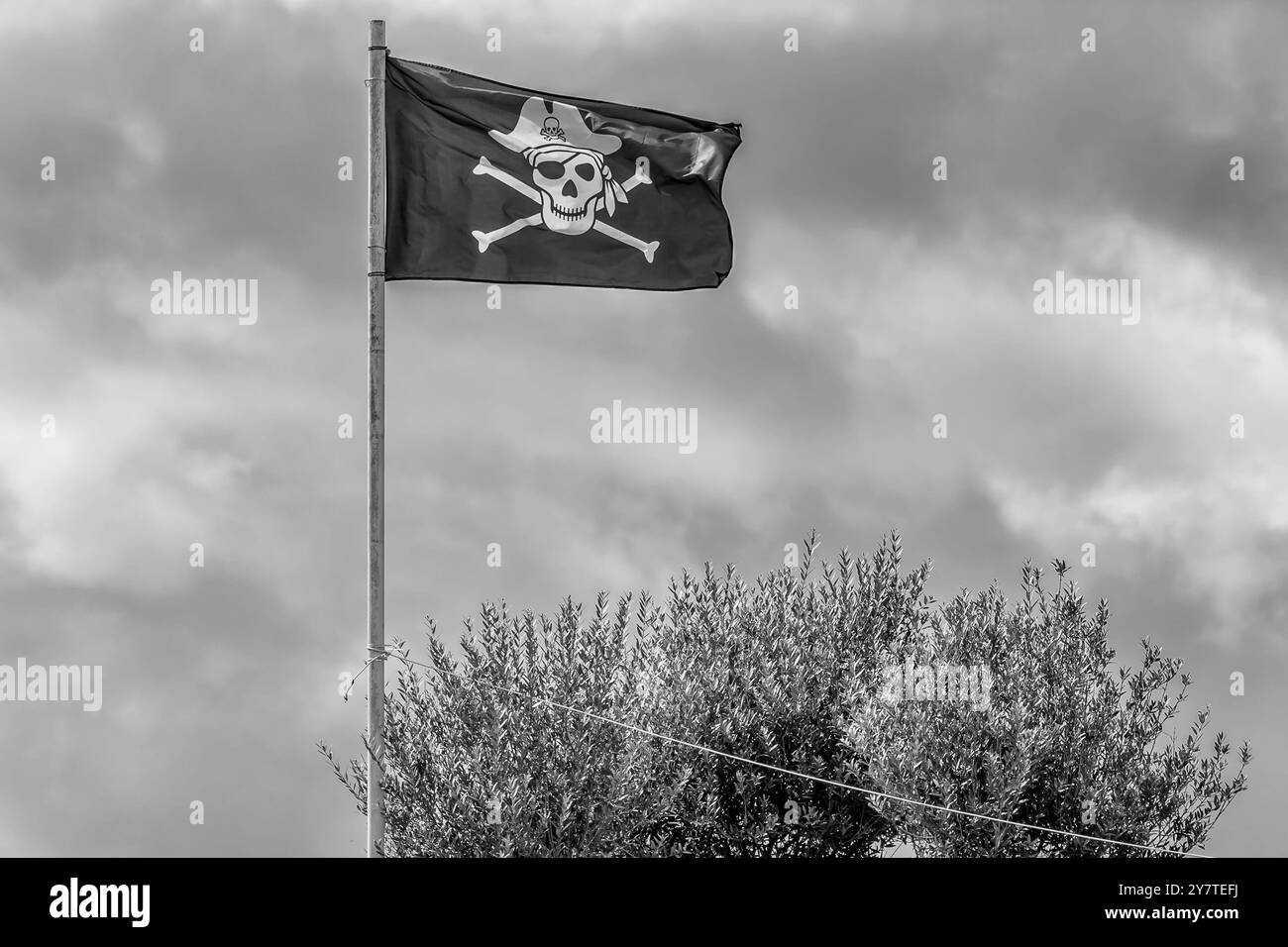 A funny pirate flag against the cloudy sky in black and white Stock ...