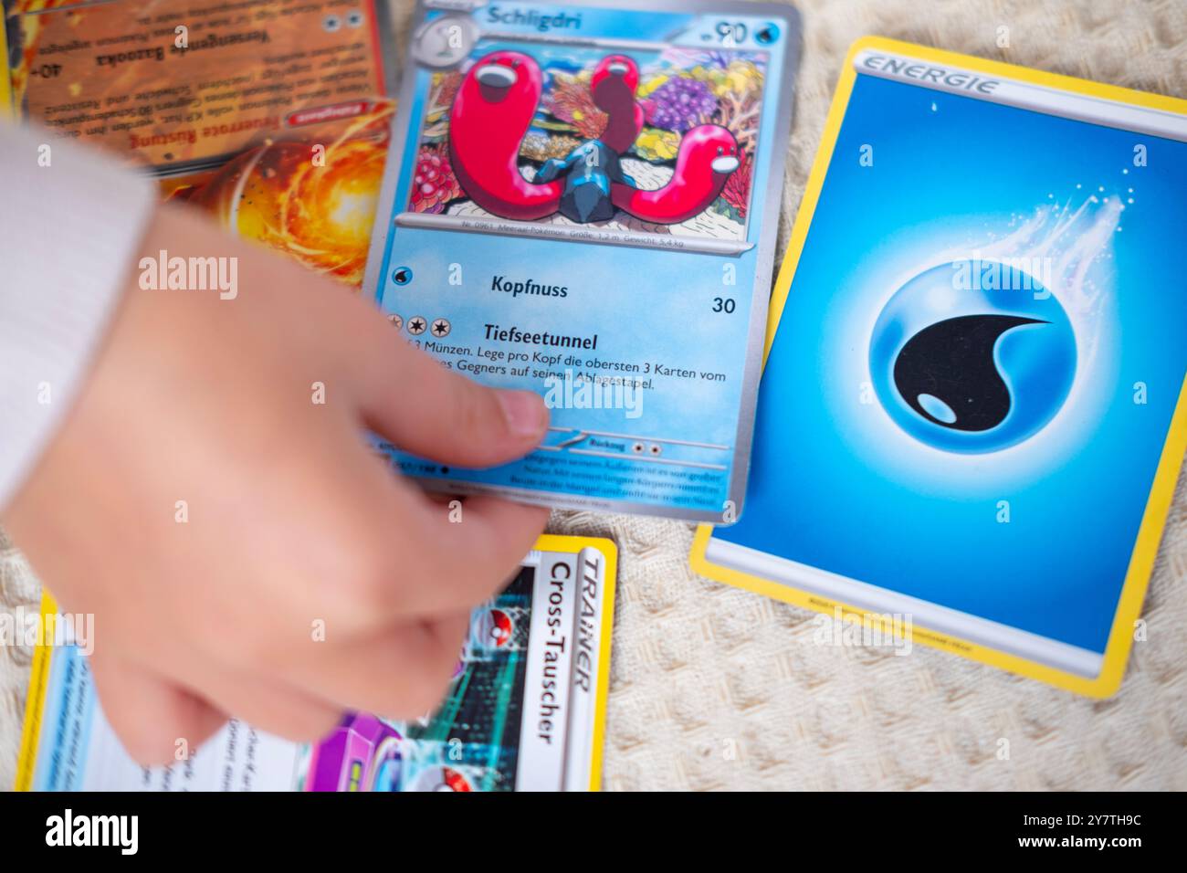 child's small hands hold favorite Pokémon card, young fan eagerly ...