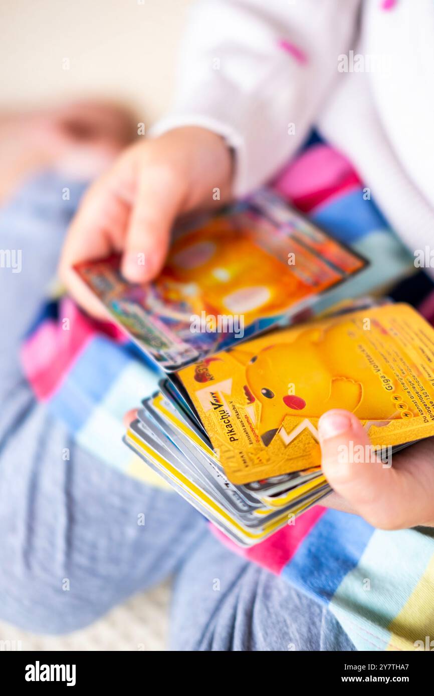 child's small hands hold favorite Pokémon card, young fan eagerly ...