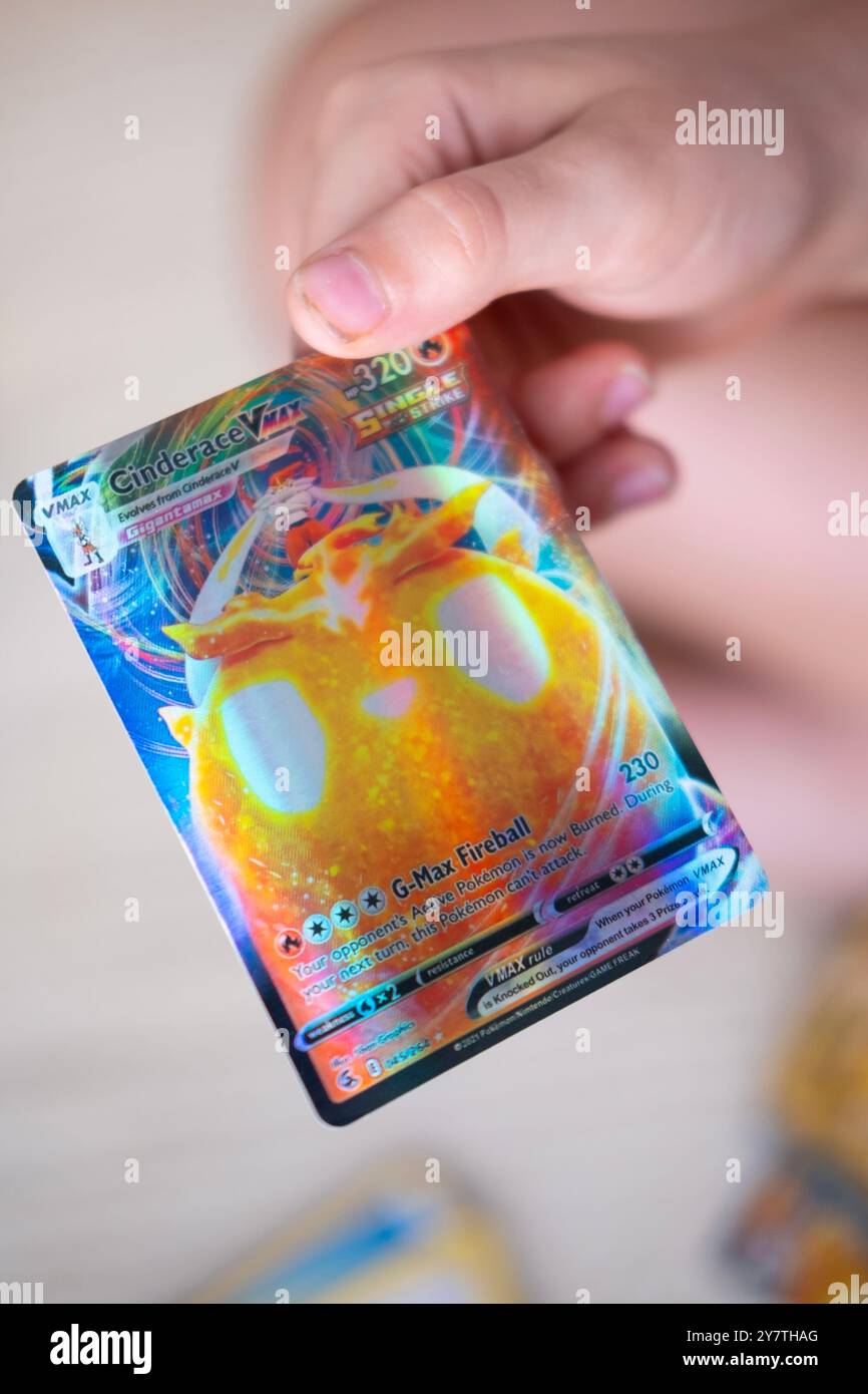 child's small hands hold favorite gold Pokémon card, young fan eagerly ...