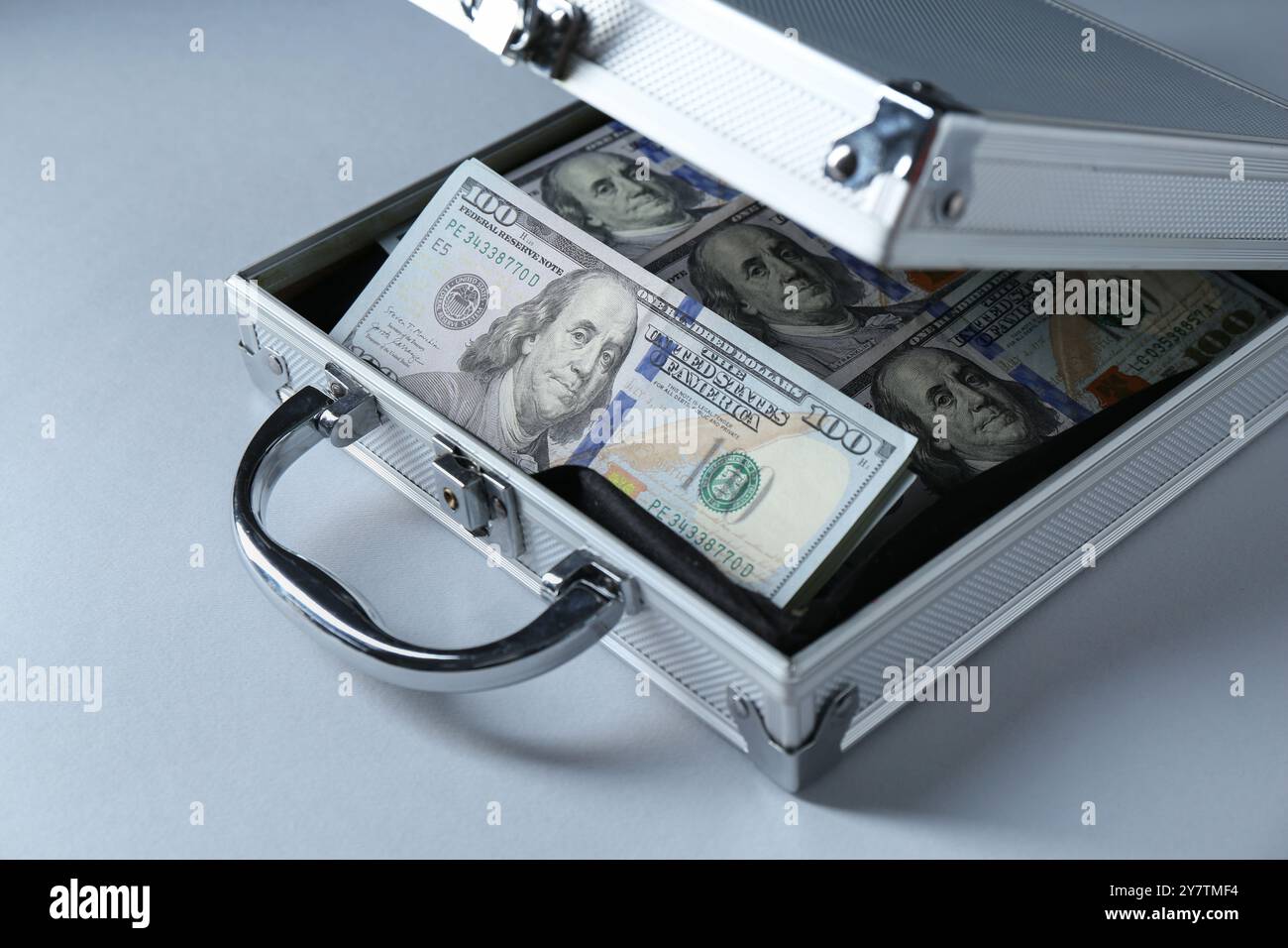 Metal case full of dollar banknotes on light background Stock Photo - Alamy