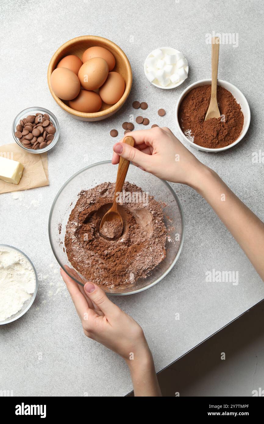 Woman making chocolate dough at light table, top view Stock Photo - Alamy
