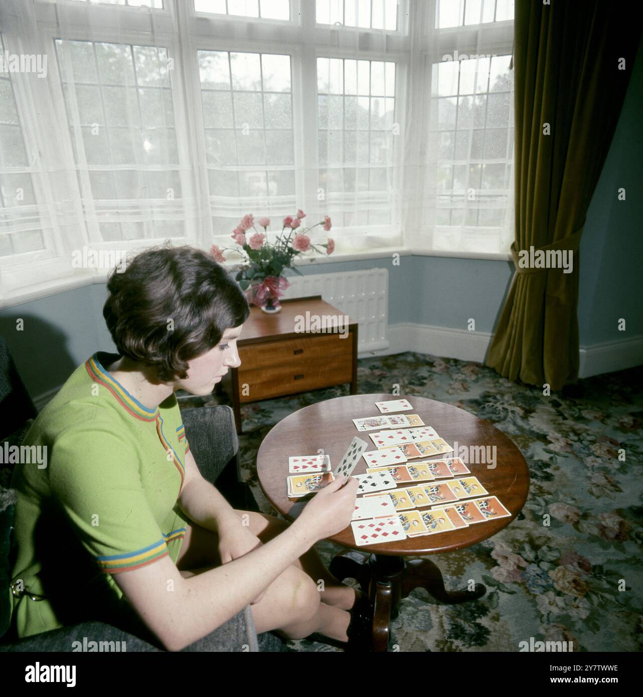 Young woman playing Solitaire in her sitting room, England.circa 1970's ...