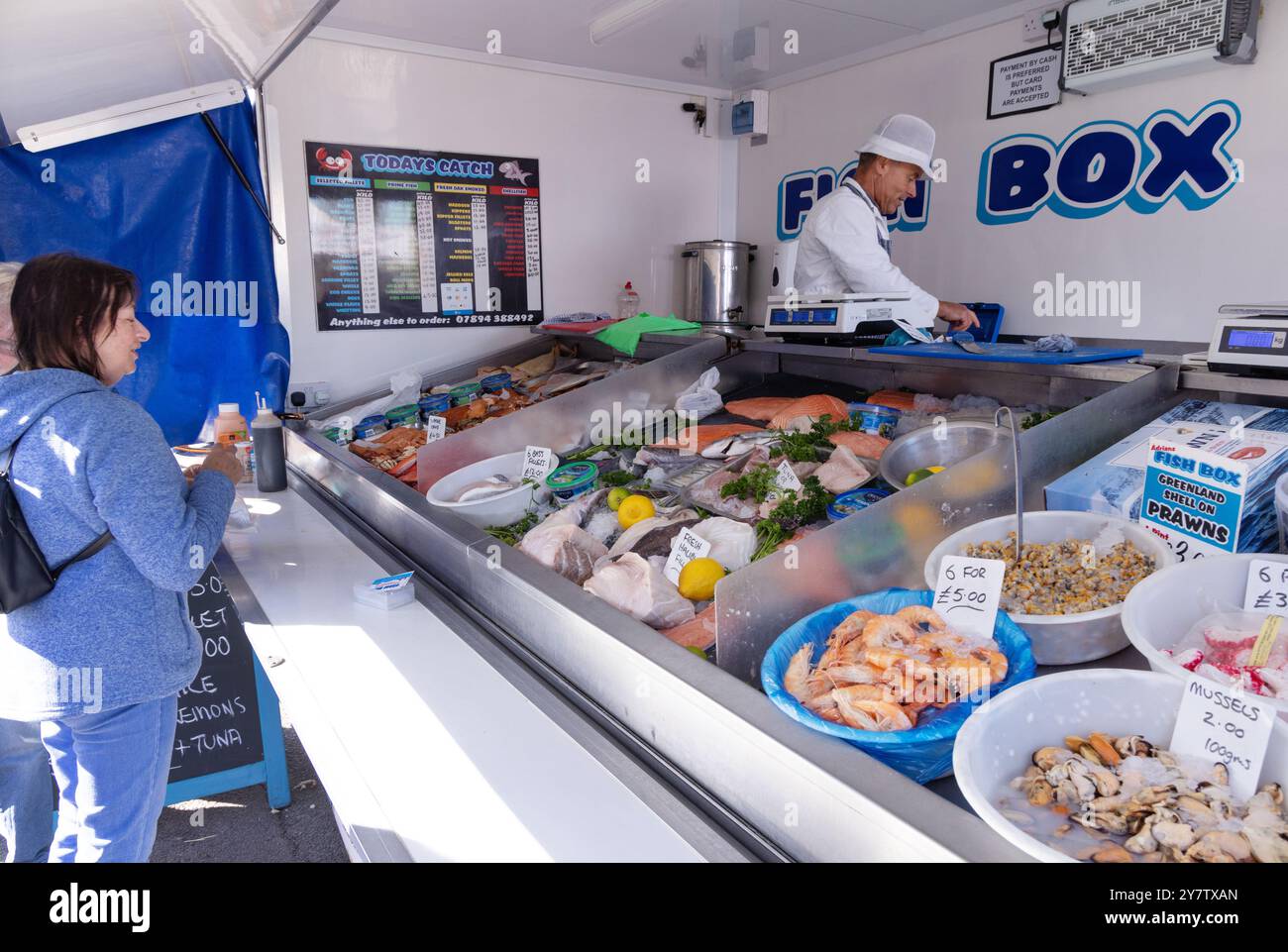 A woman shopping at a seafood stall, Fish Box fishmonger, Sheringham ...
