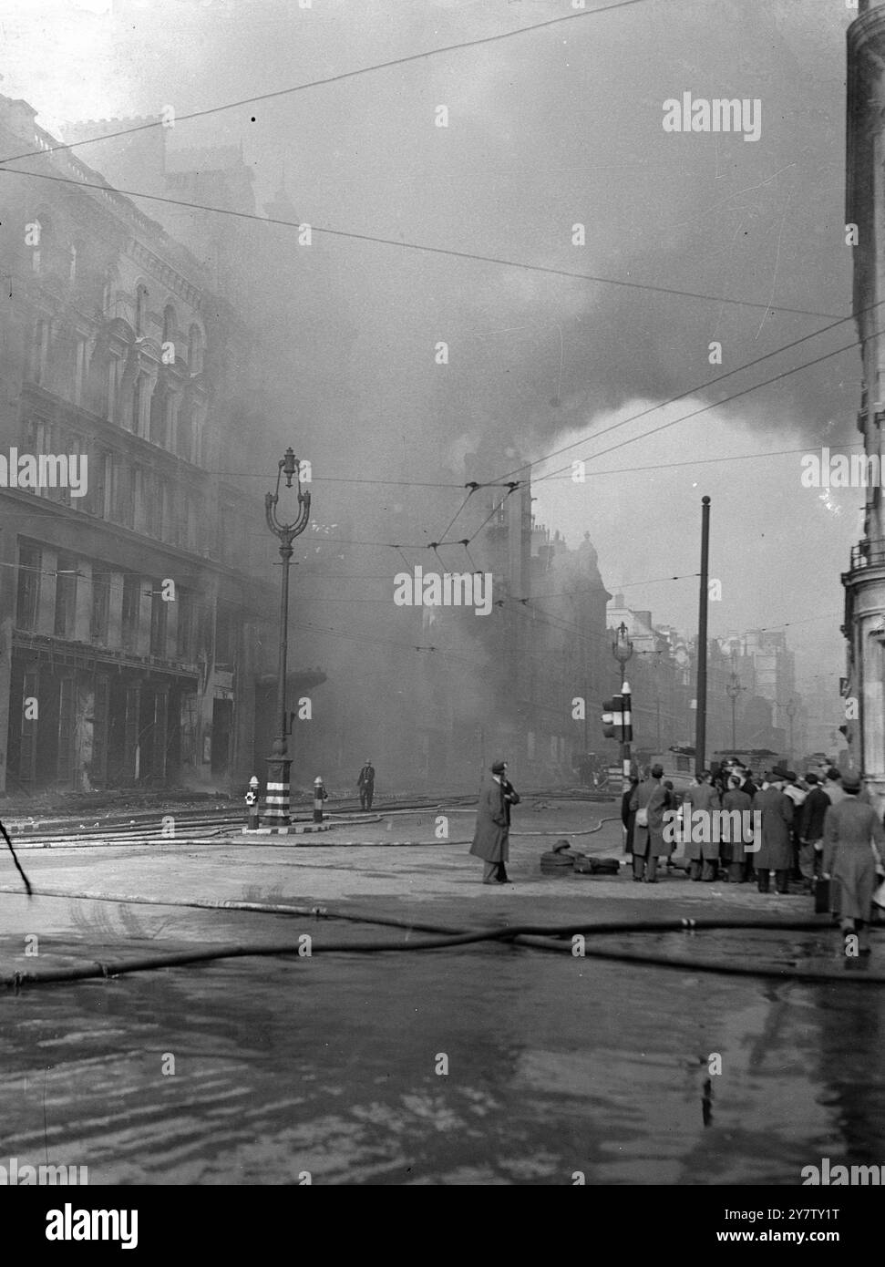 Firemen fighting a fire in a London Street, after the worst Nazi fire ...