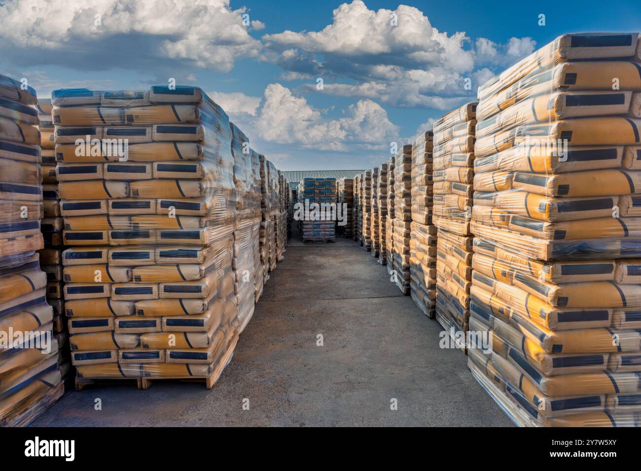huge stack of cement paper bags stored in the yard outdoors, in a ...