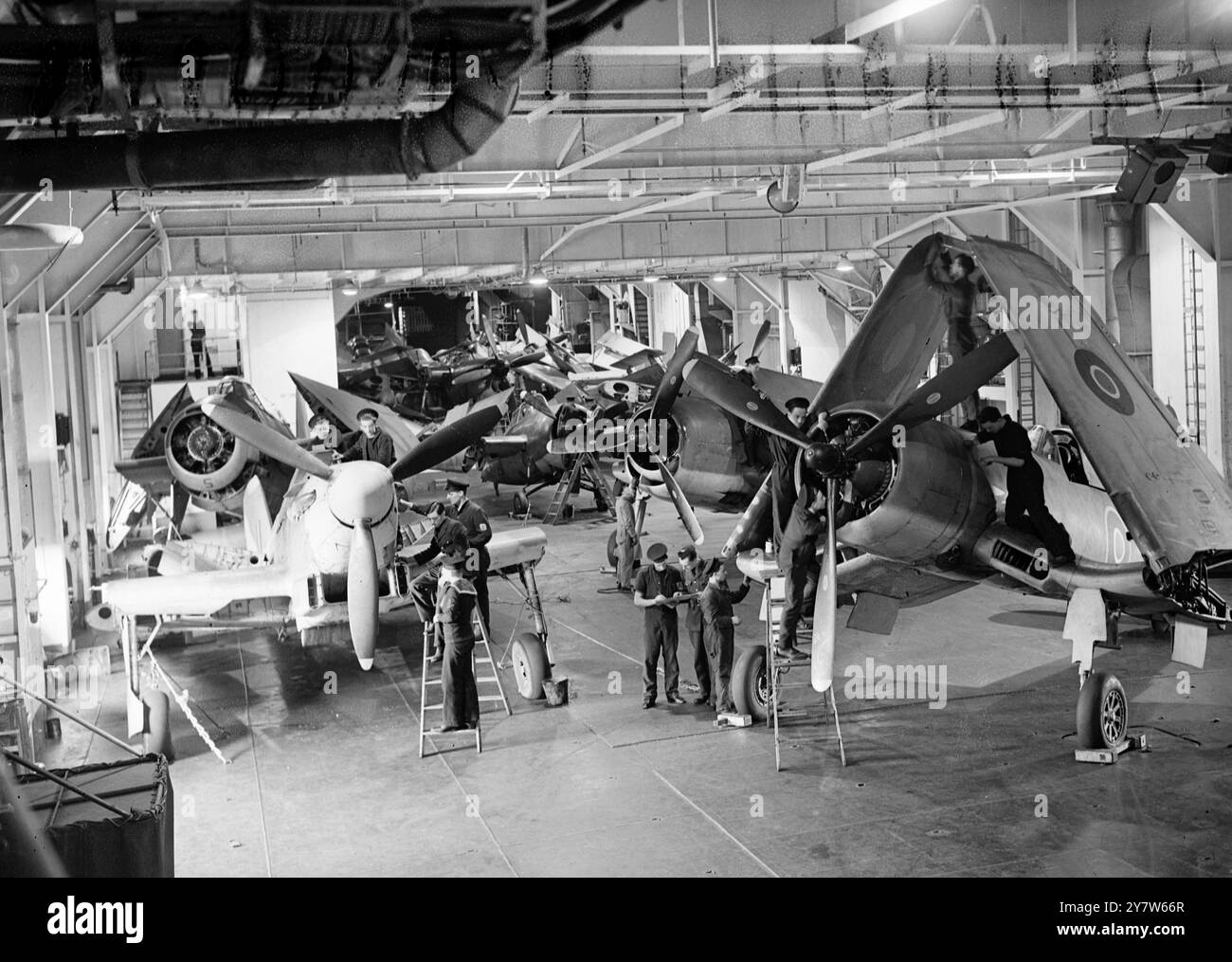 BELOW DECKS ON AN ESCORT CARRIER Photo Shows: Flight mechanics ...