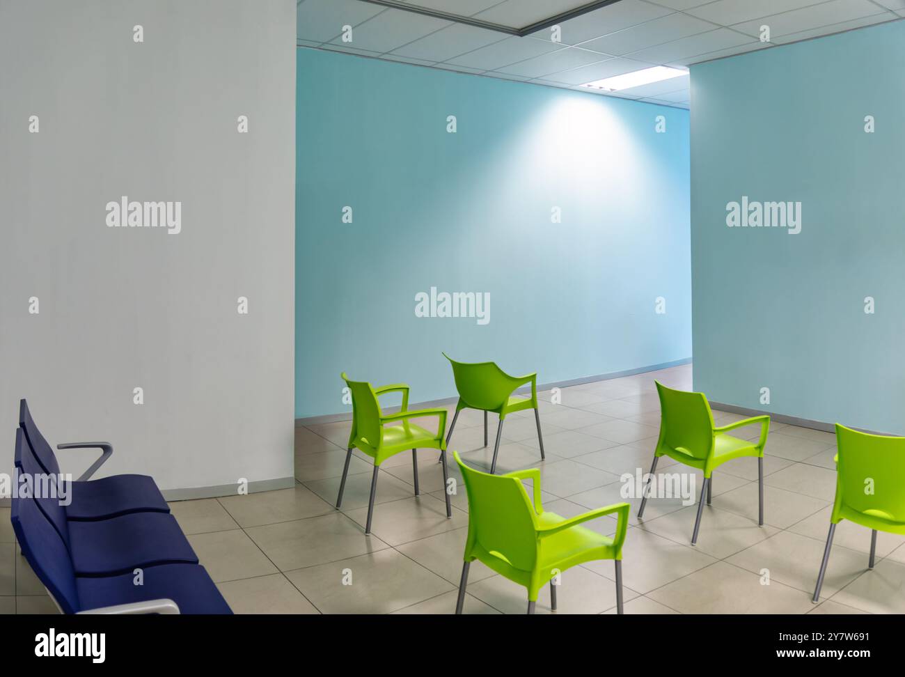 generic partitioned waiting room with plastic green chairs and blue ...
