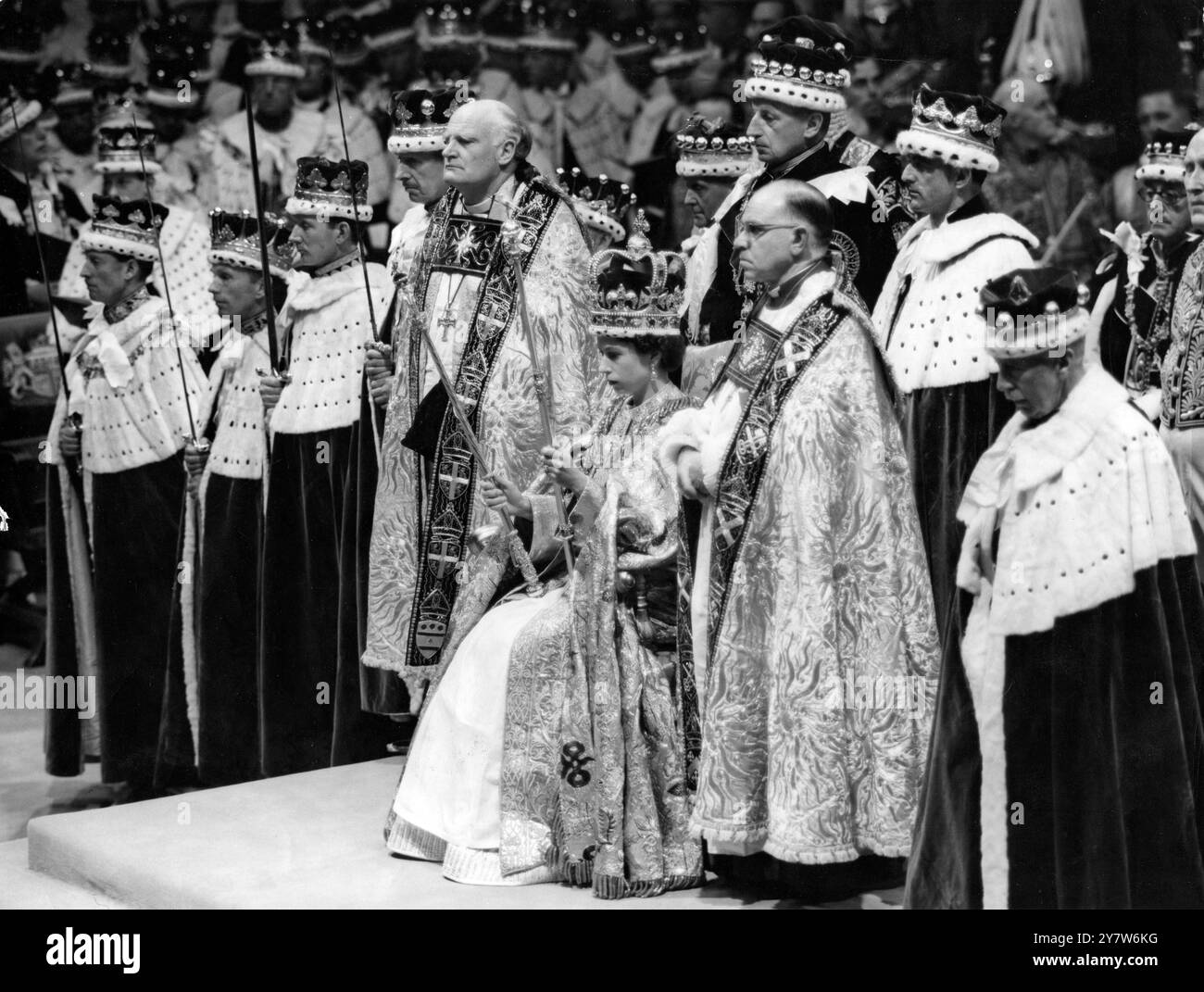 The Queen, seated upon the Throne and wearing St Edward's Crown, holds ...