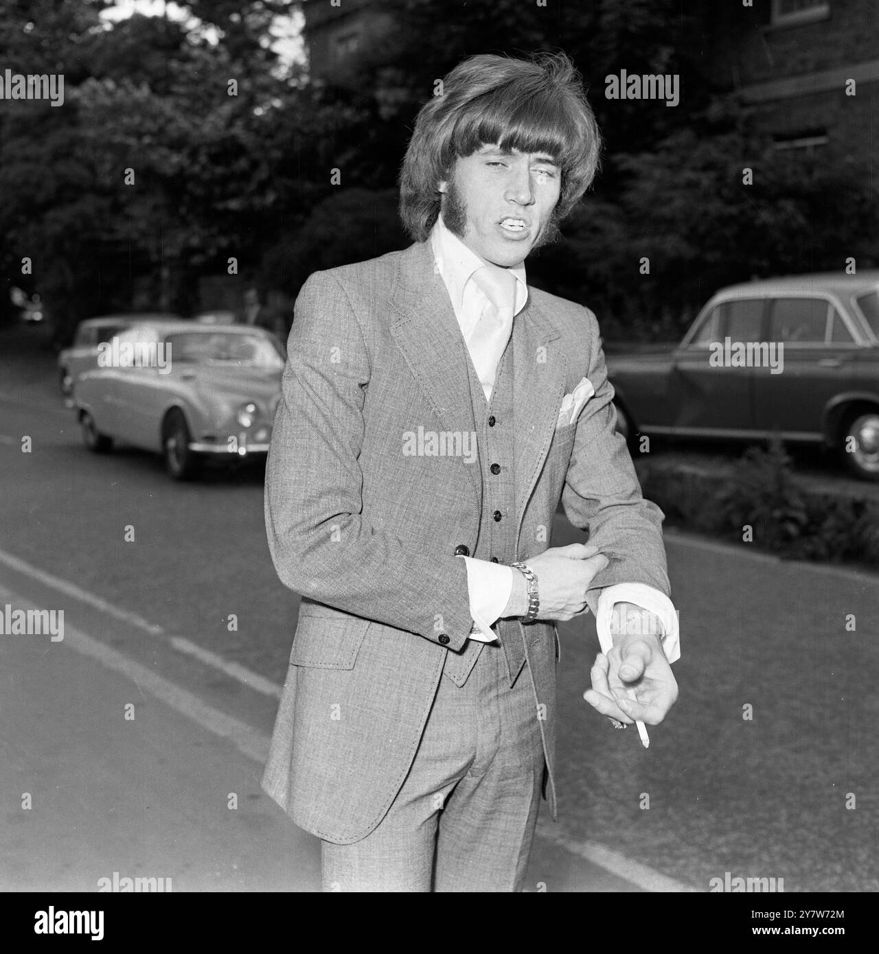 Bee Gees lead singer Barry Gibb, wearing a Recency style grey suit ...