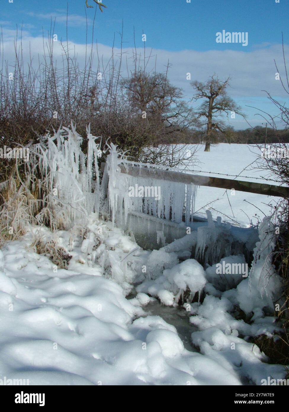 Ice formed by water from a broken water pipe on a cattle trough on a ...