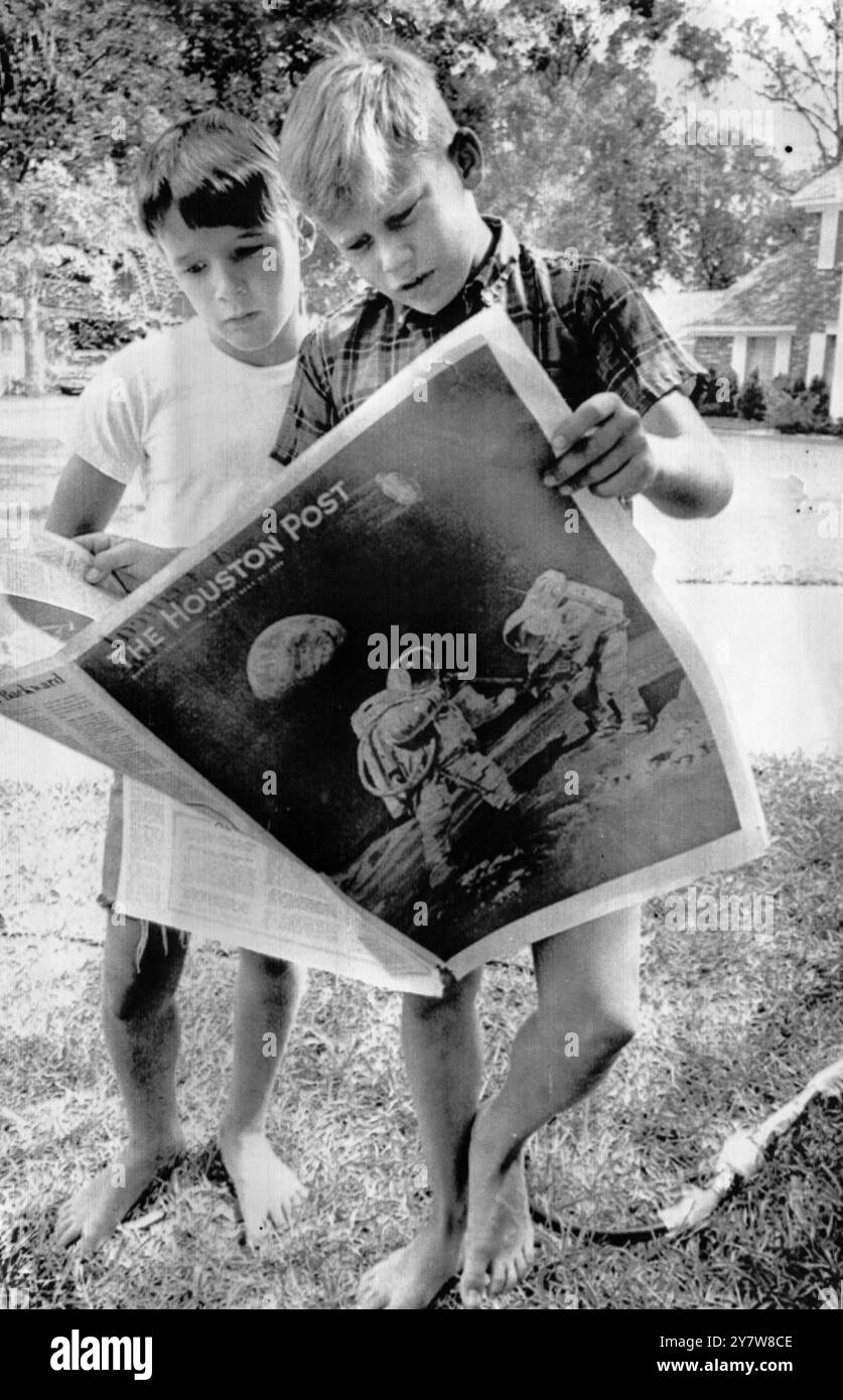 Andrew Aldrin (right), son of Edwin Buzz Aldrin, reads a newspaper with ...