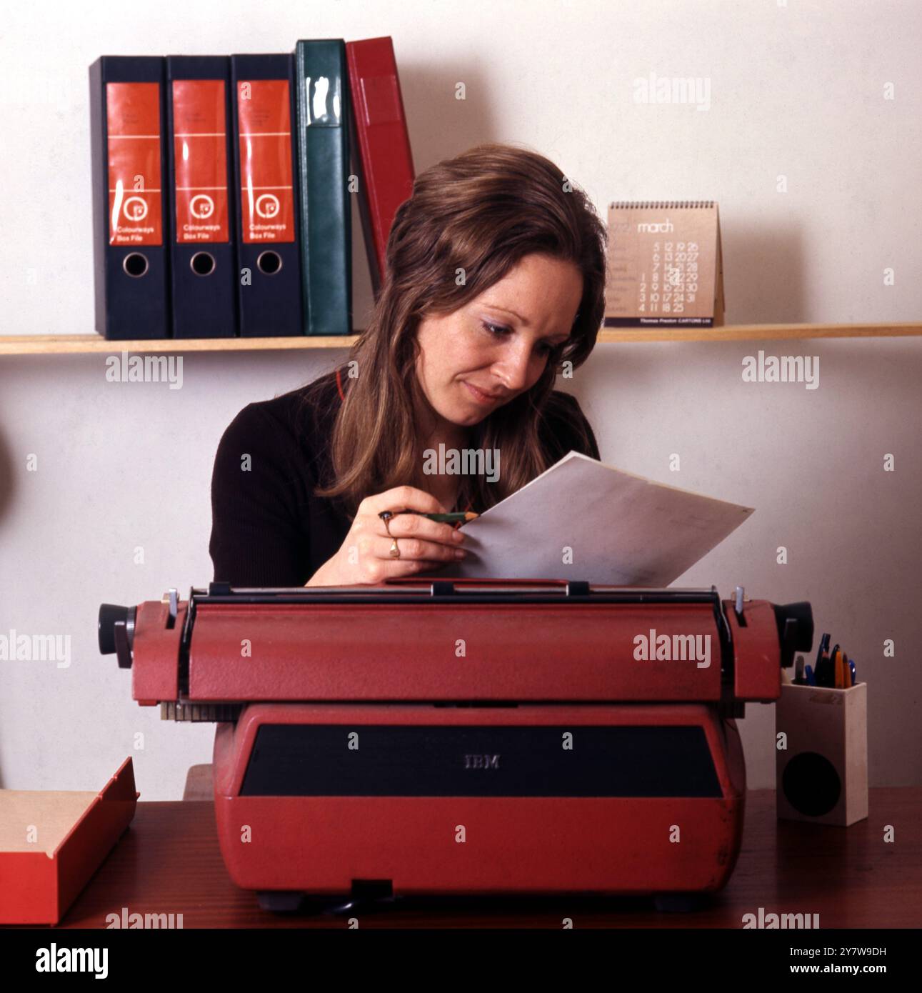 Secretary at work typing on an typewriter in an office in the 70s Stock ...