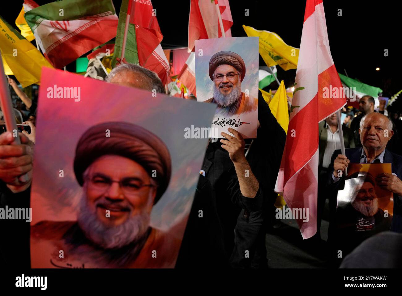 Iranian demonstrators hold posters of slain Hezbollah leader Hassan ...