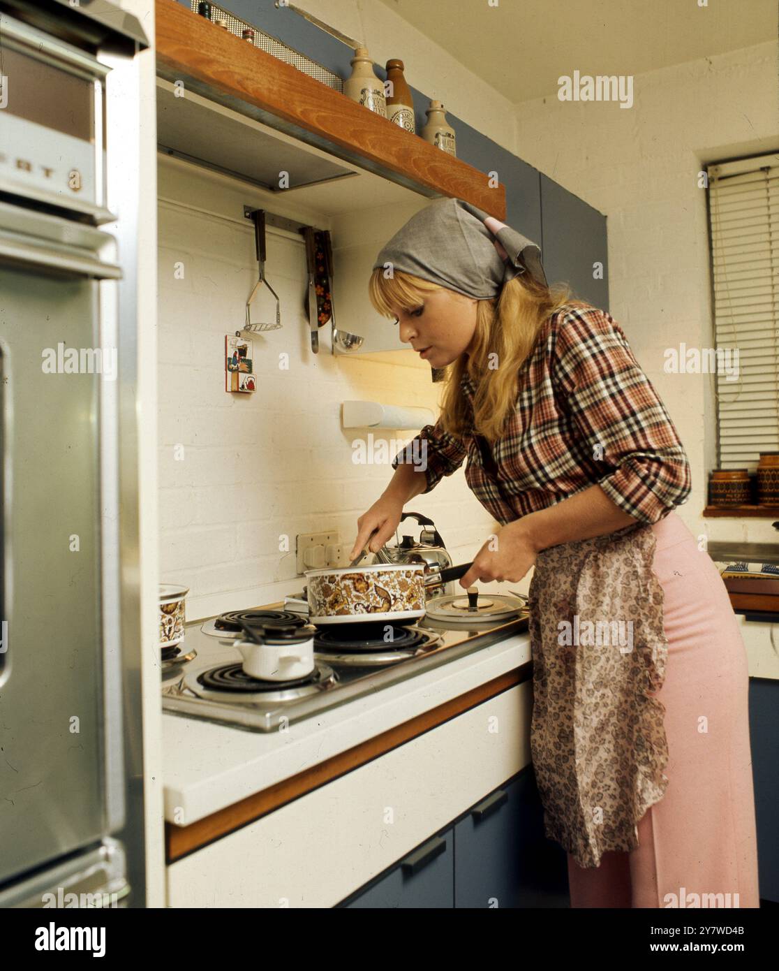 A woman cooking in the kitchen. 1970's Stock Photo - Alamy