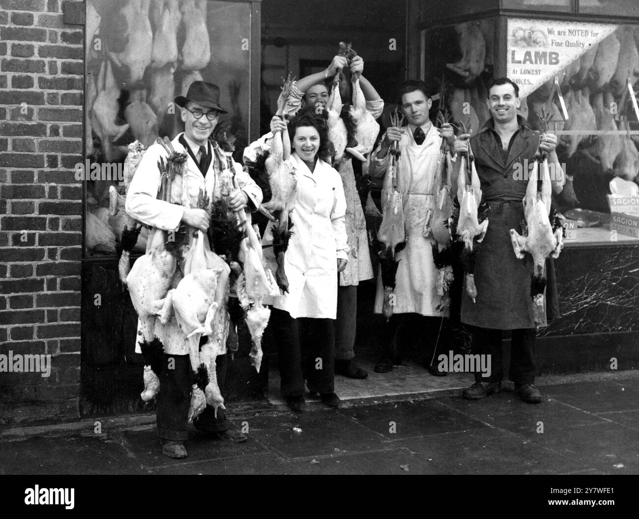 Butchers shop with shop workers standing outside holding poultry - 1947 ...