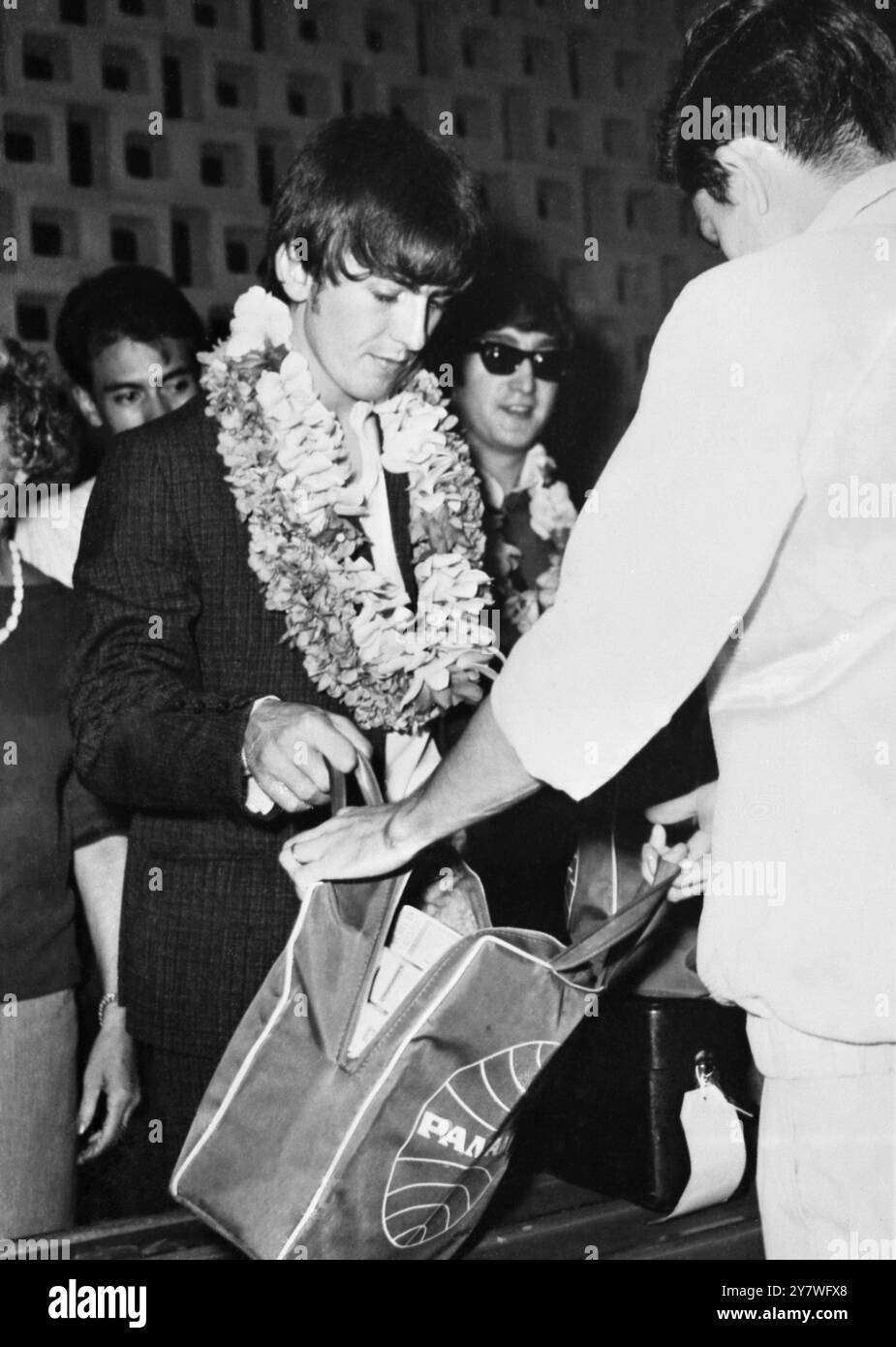 The Beatles - George Harrison (left) having his bag checked by customs ...