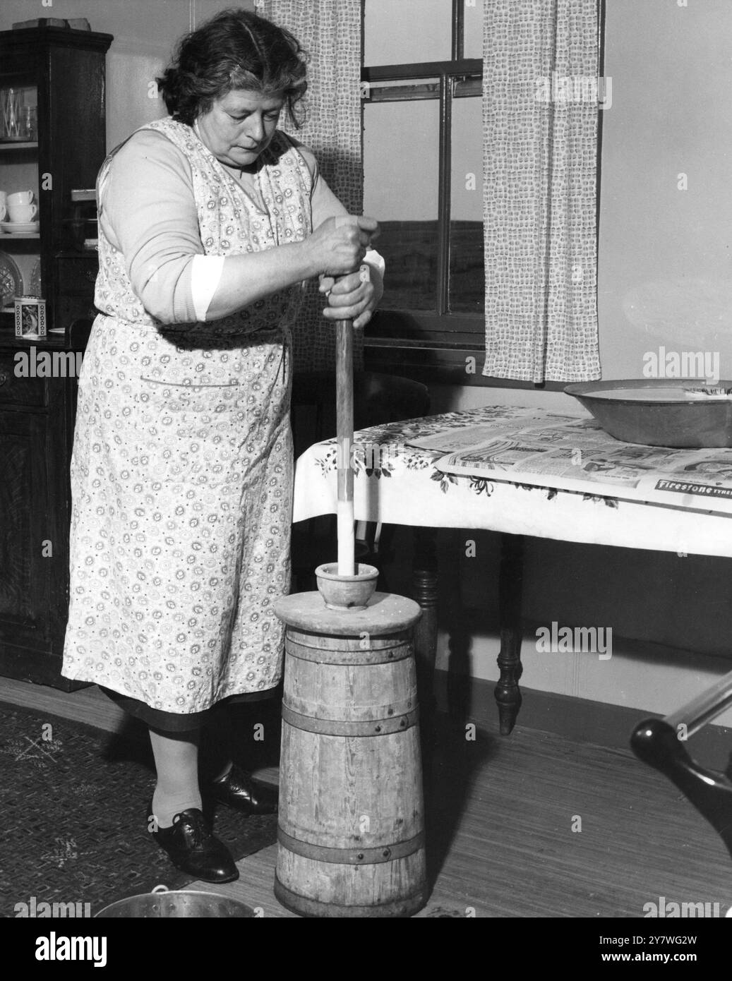 Miss Peggy Macleod making butter using the plunger in Daliburgh South ...