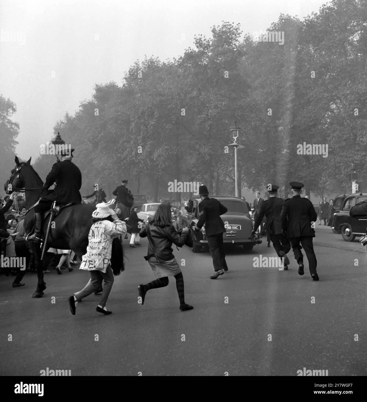 Fans chase the car carrying The Beatles after they left Buckingham ...