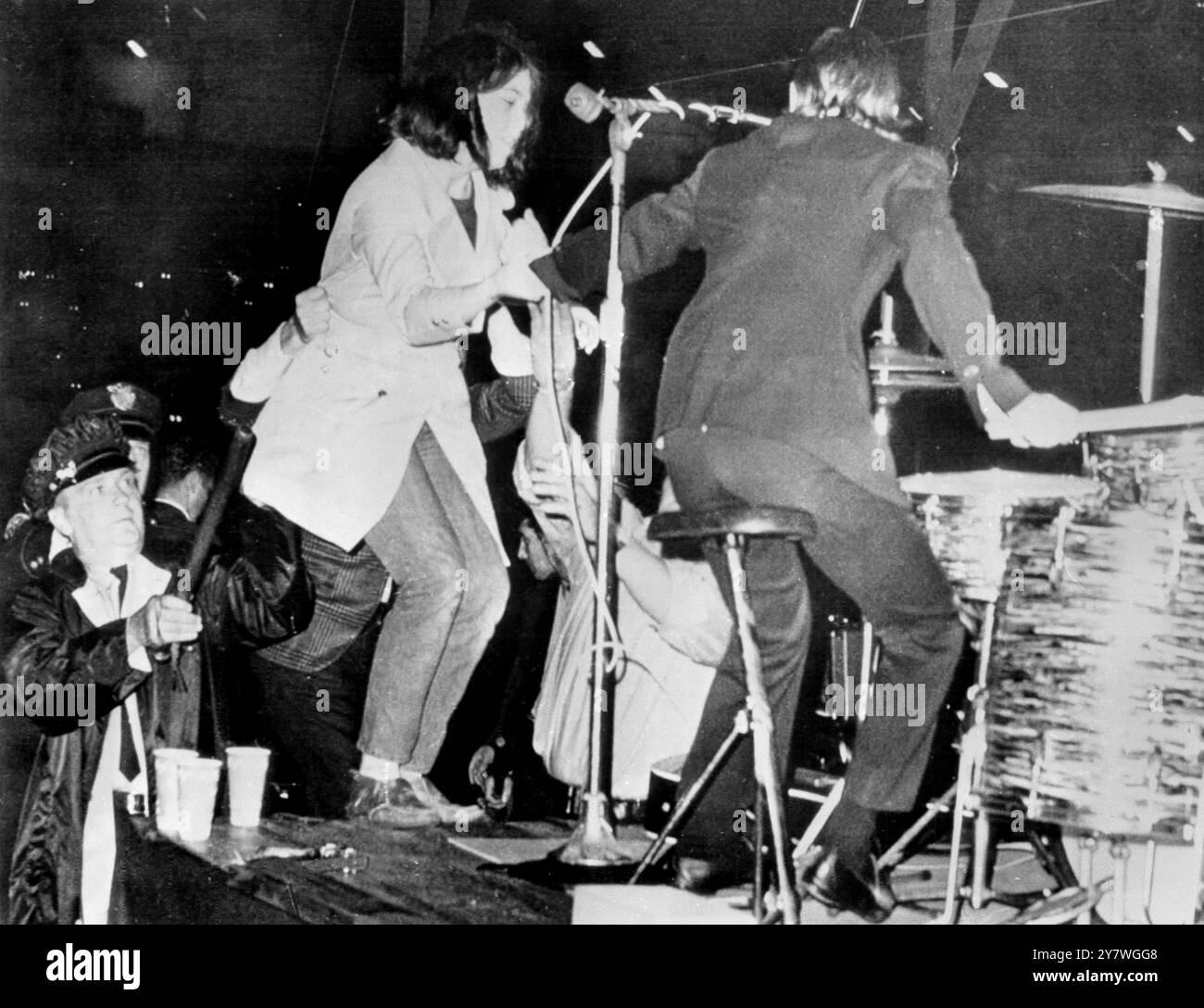 A fan gets on stage to grab the arm of Ringo Starr during a Beatles ...