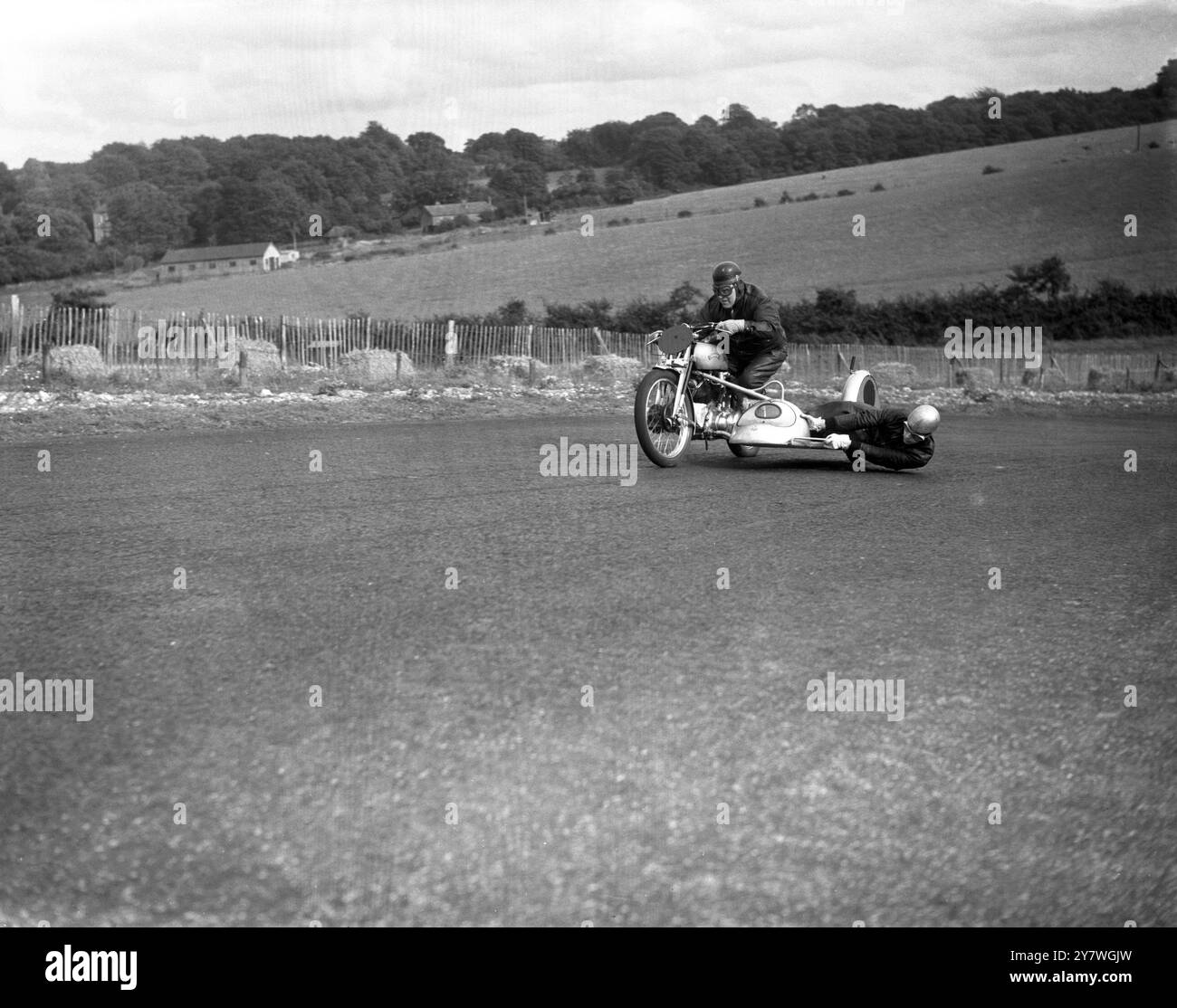 John Surtees hangs over the motorcycle side - car to balance the wheel ...