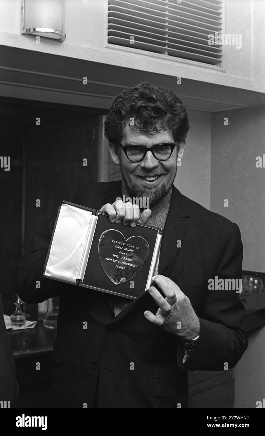 Rolf Harris , showing the mounted and inscribed silver heart he ...