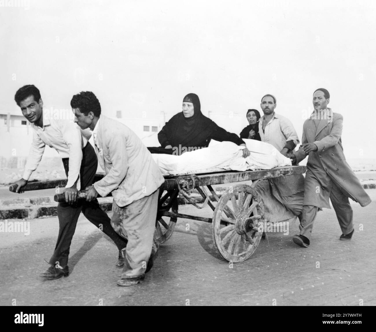 Port Said , Egypt : A woman mourner sits on a cart containing a dead ...