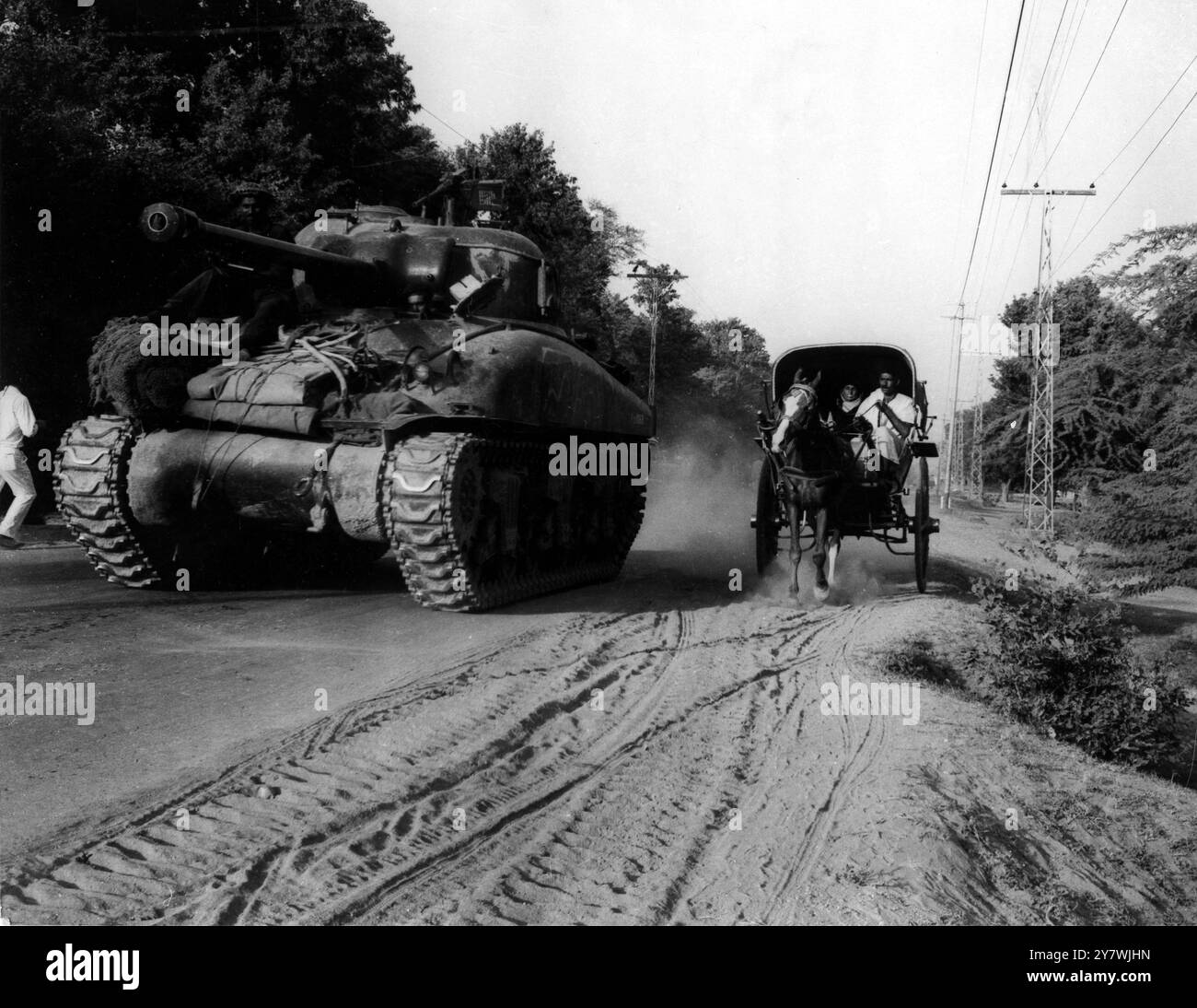 A Pakistani army Sherman Tank rumbles past a buggy cart carrying local ...
