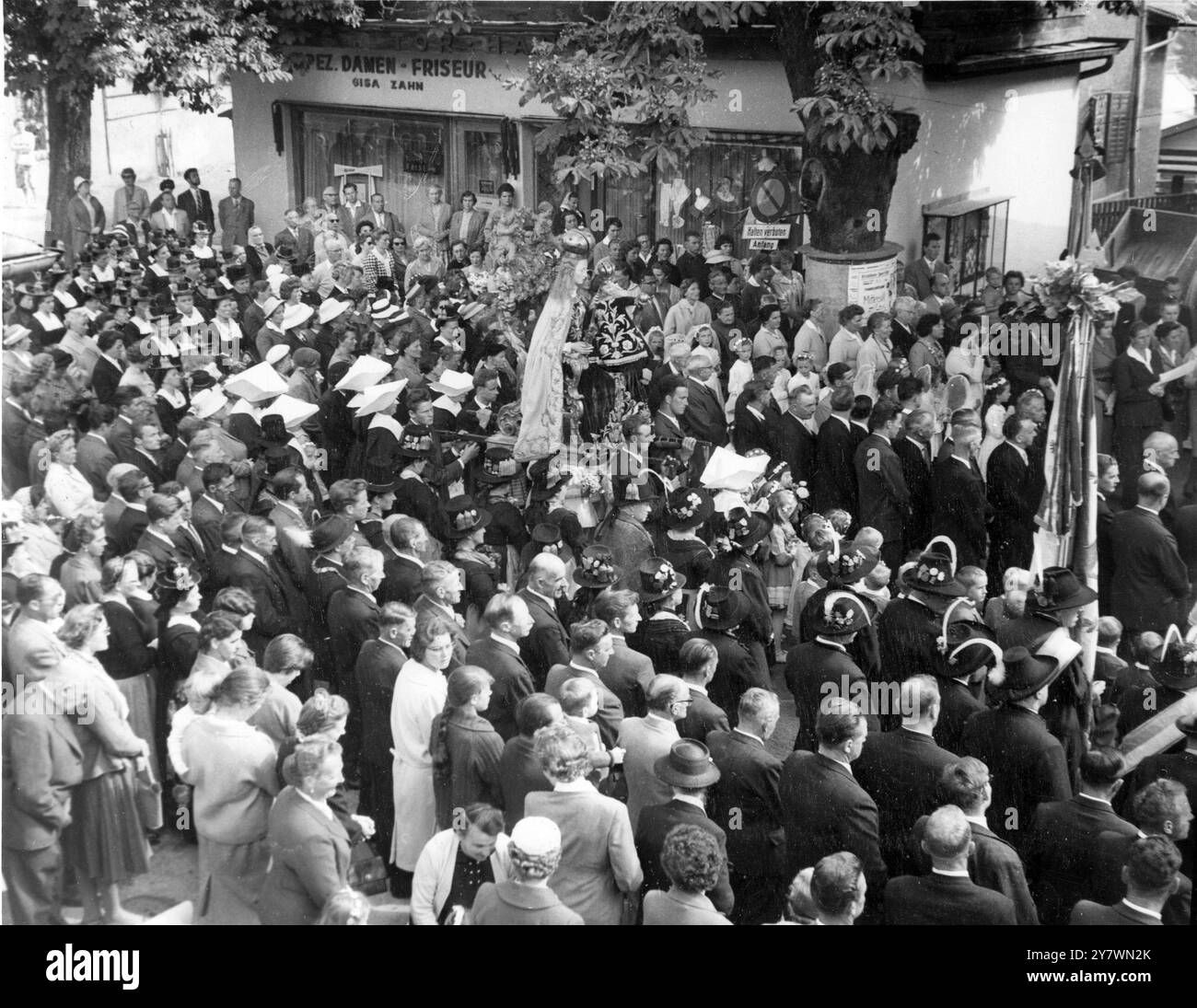 A statue of the Virgin Mary is carried in solemn procession through the ...