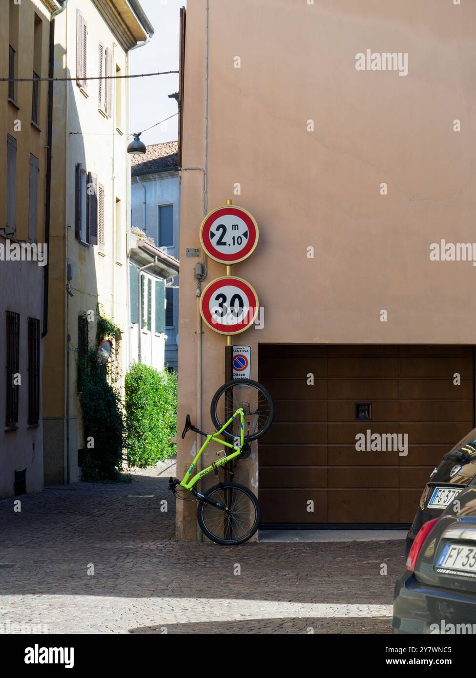 Mantua, Italy September 30th 2024 A lime green bicycle is leaning ...