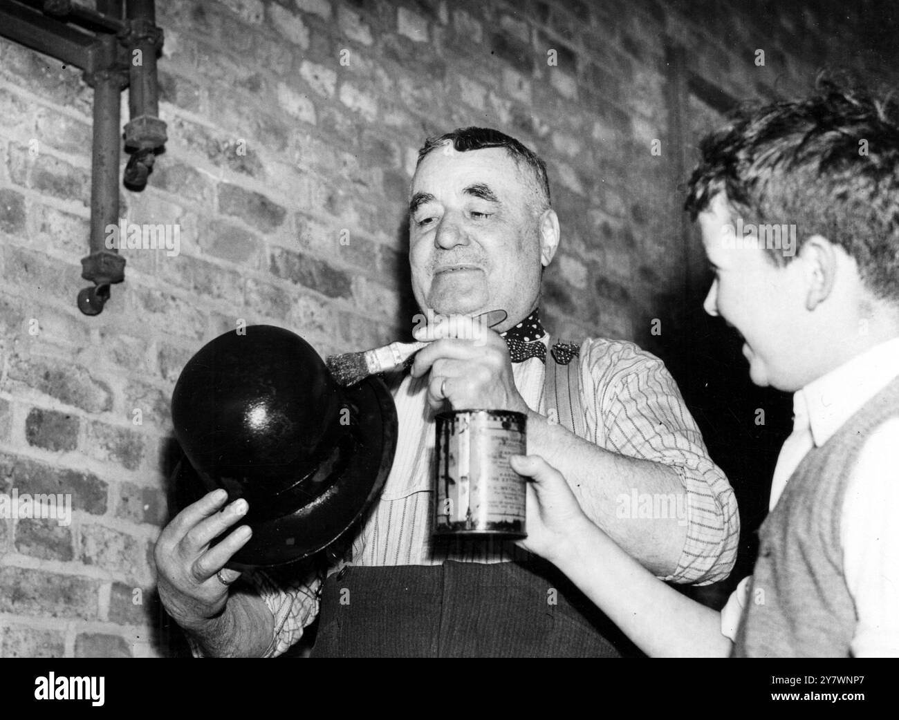 Charles Hever, local man, painting his bowler hat with black enamel ...