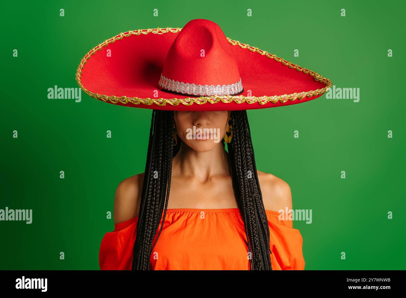 Gorgeous young Mexican woman in Sombrero standing against green ...
