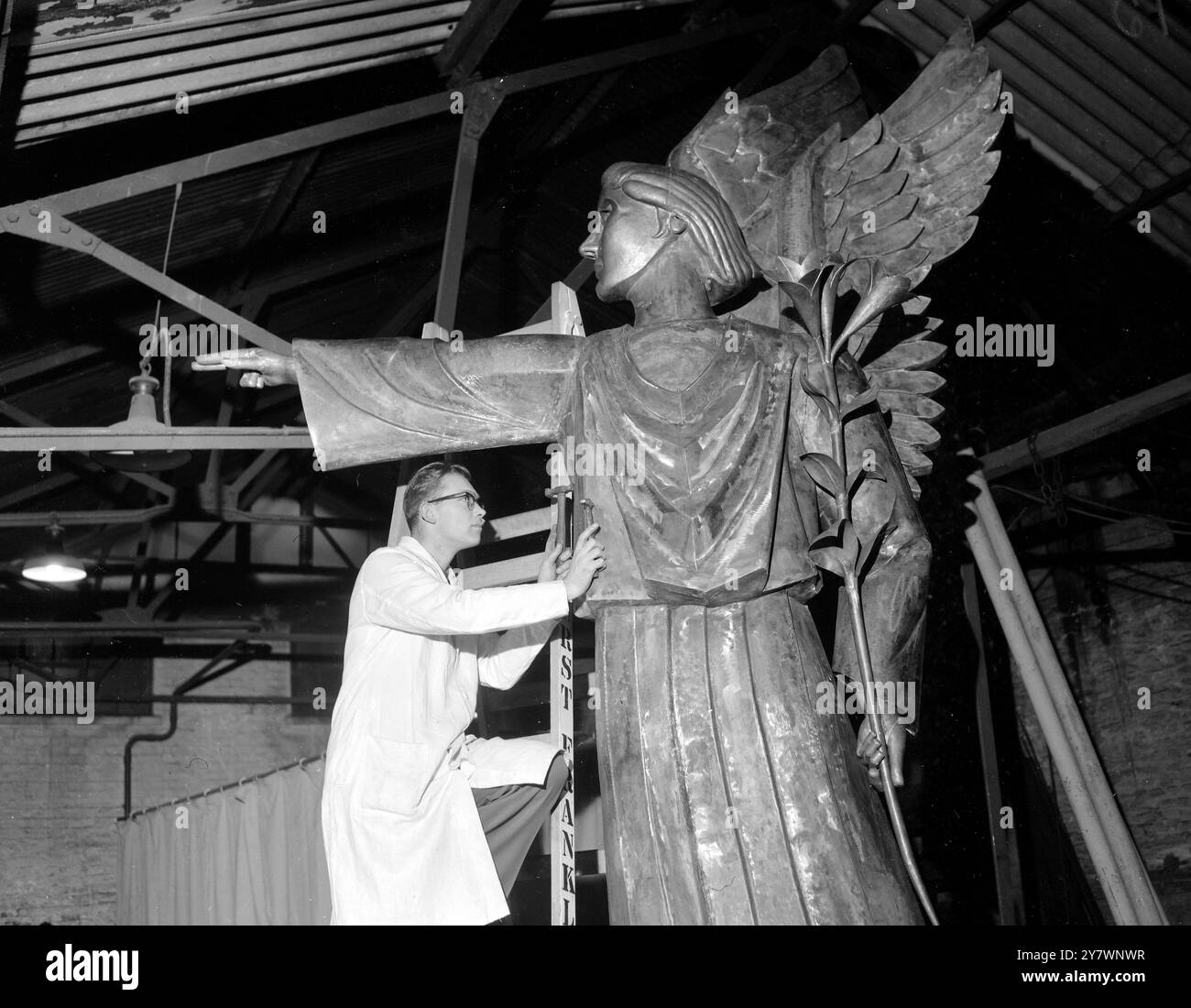 London: Workman Mr Alfred Rose ( centre) beats on of the sheets of ...