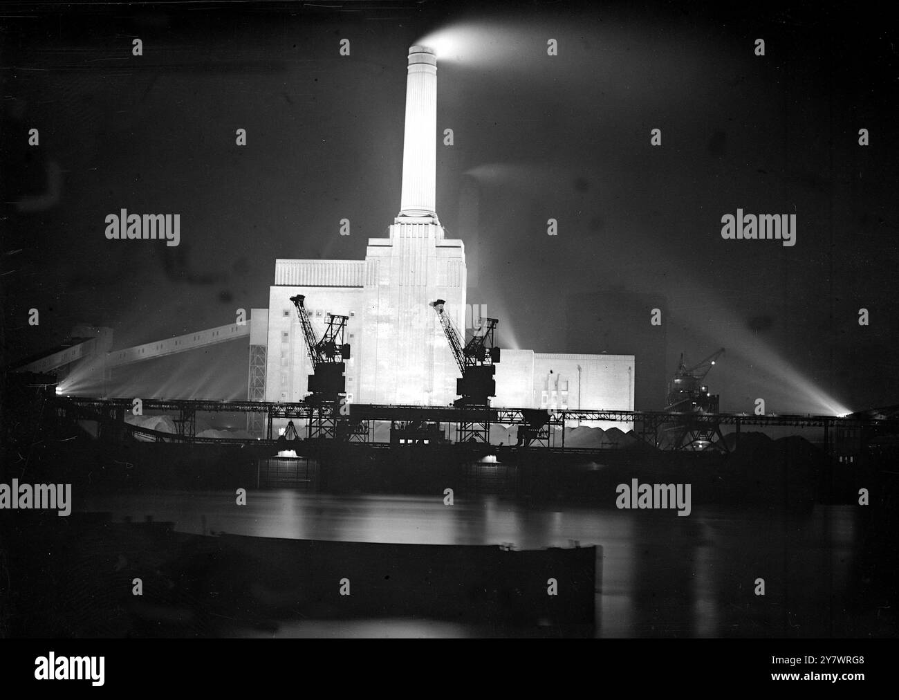 Battersea Power Station lit up by lights by night , by the River Thames ...